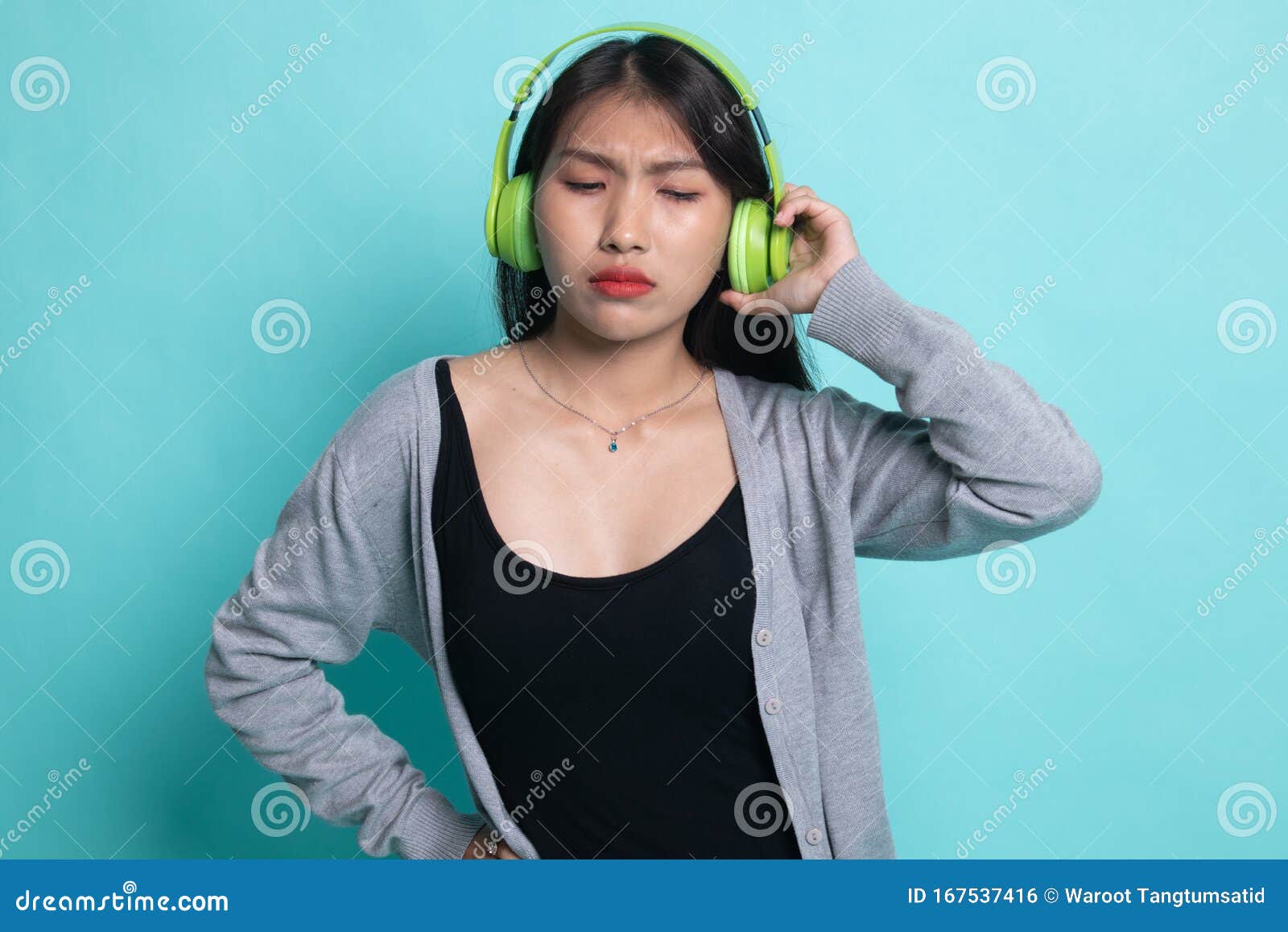 Too Loud. Portrait of Young Asian Woman Holding Headphones and Making ... Too Loud. Portrait of Young Asian Woman Holding Headphones and Making ...