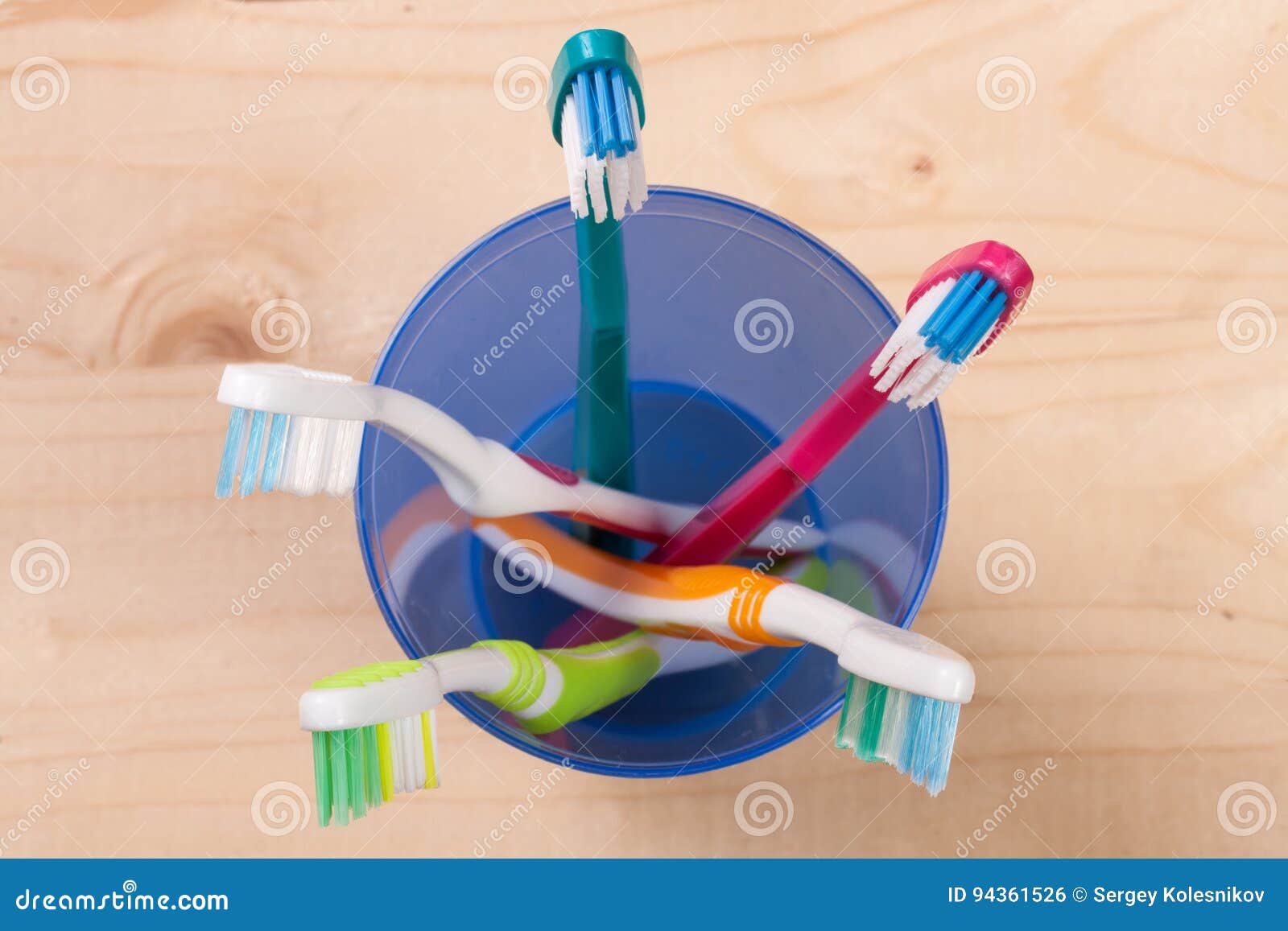 Toothbrushes in a Blue Plastic Glass on a Light Wooden Background Stock ...
