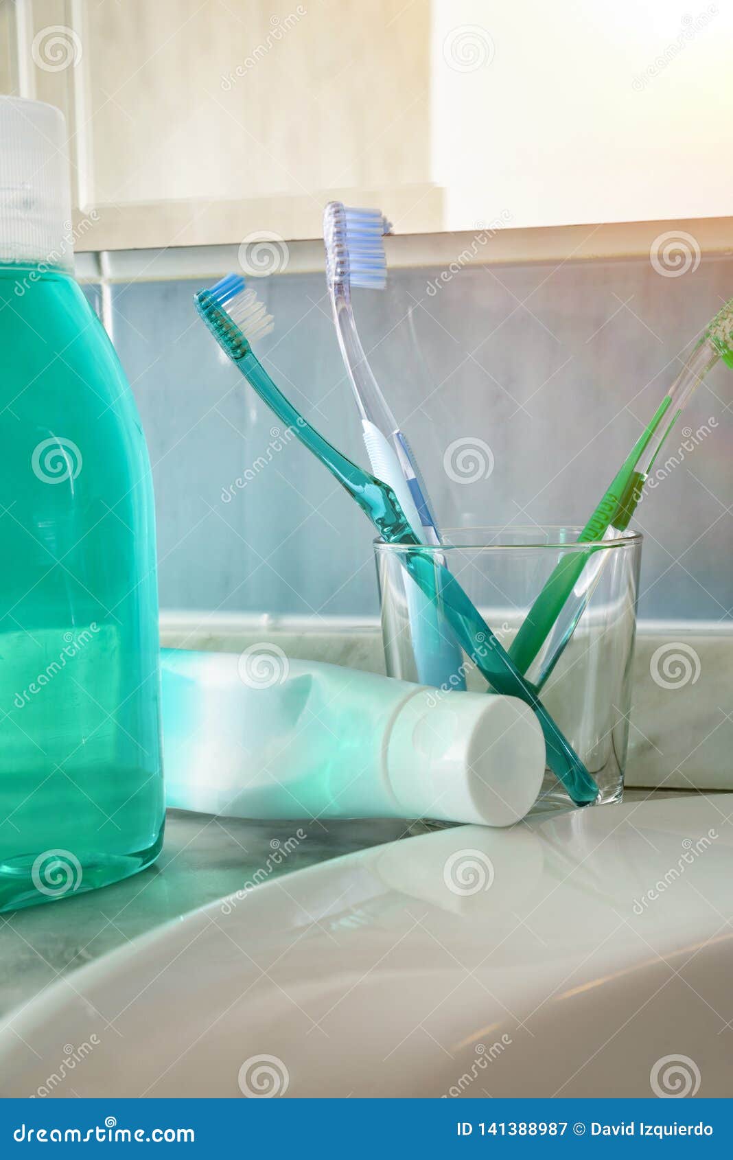 Toothbrushes Toothpaste and Mouthwash on a Sink Vertical Stock Image ...