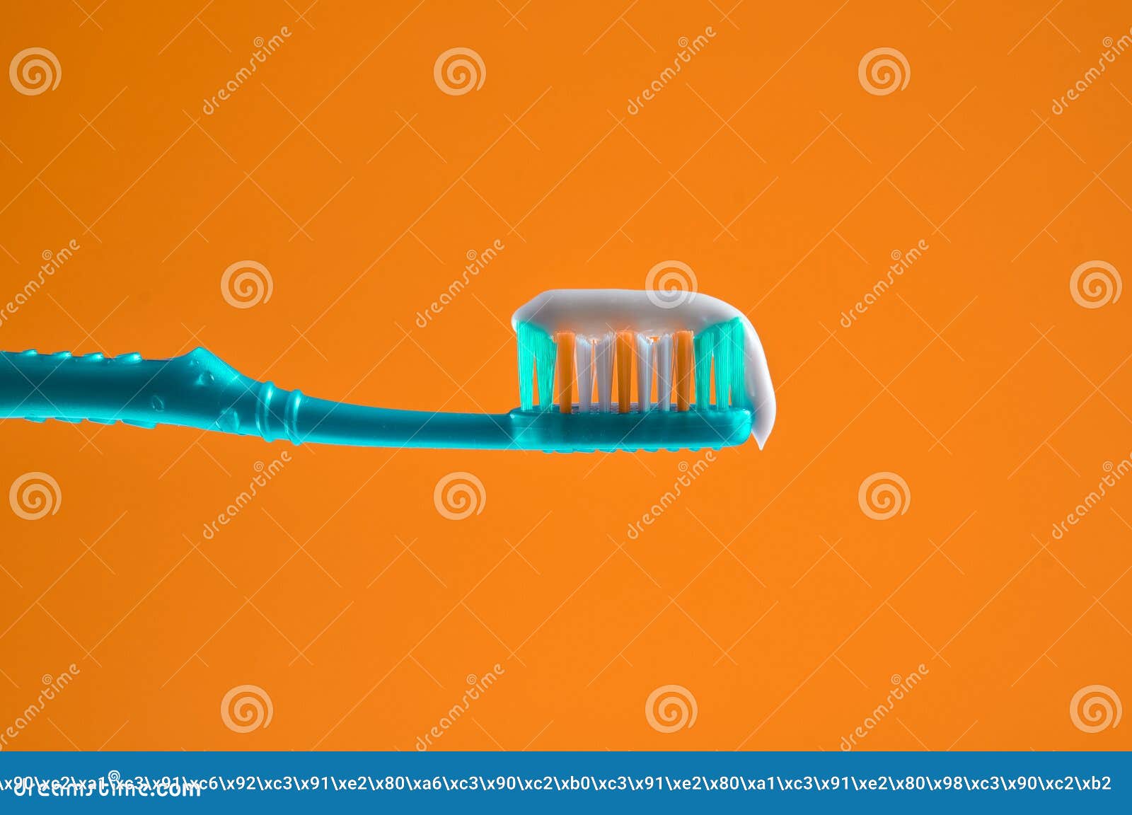 Toothpaste on a Blue Toothbrush Close-up on an Orange Light Background ...