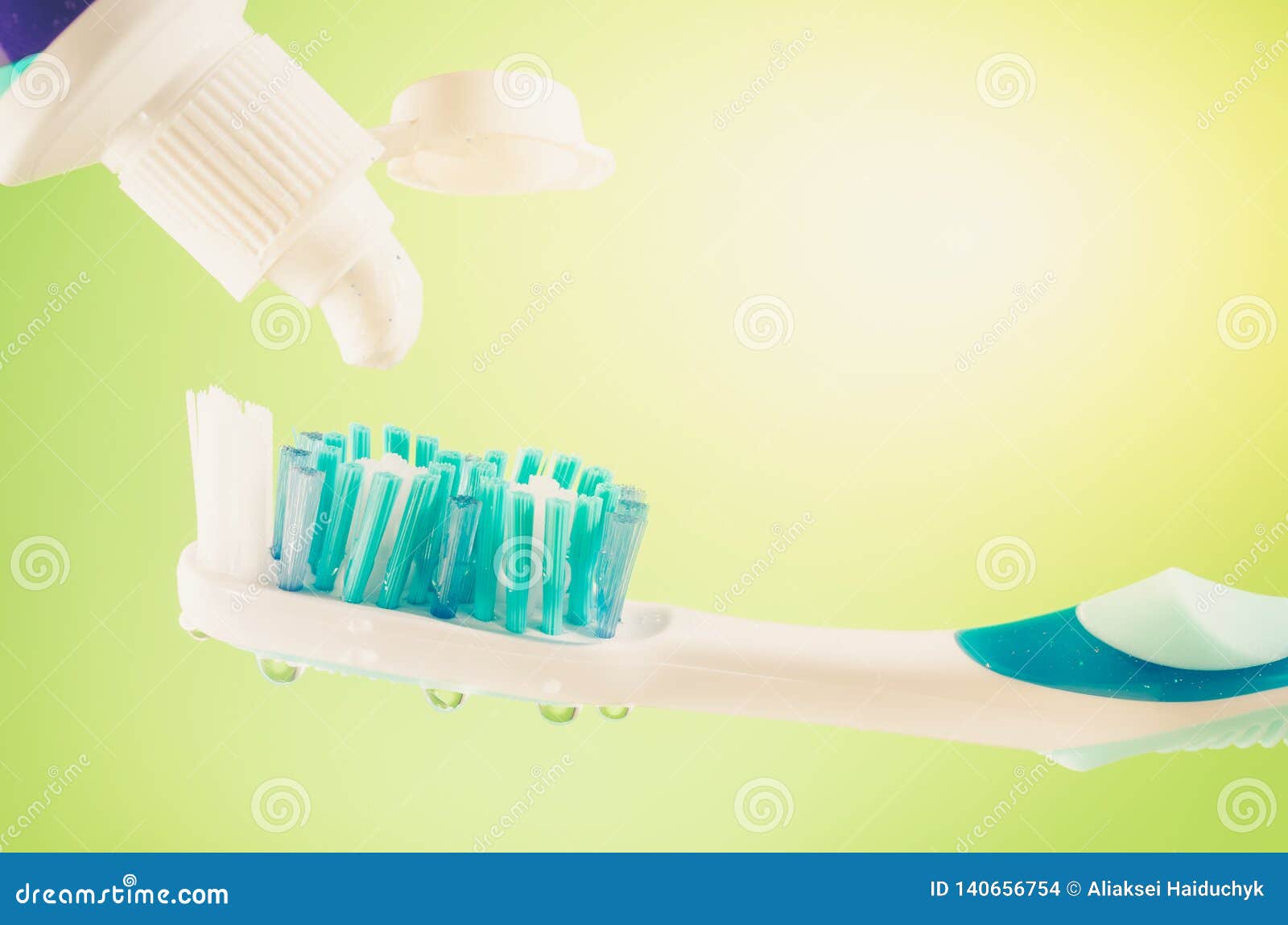 Toothpaste Squeezed from Tube Onto Brush on a Green Background, Close ...