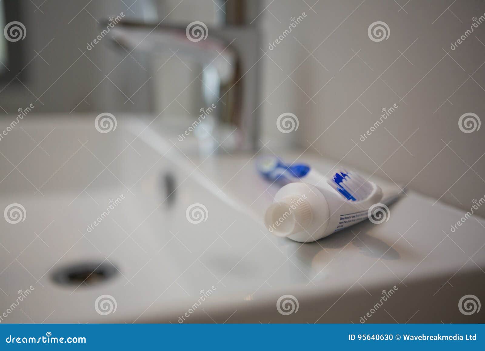 Toothpaste Tube and Toothbrush on a Bathroom Sink Stock Photo - Image ...