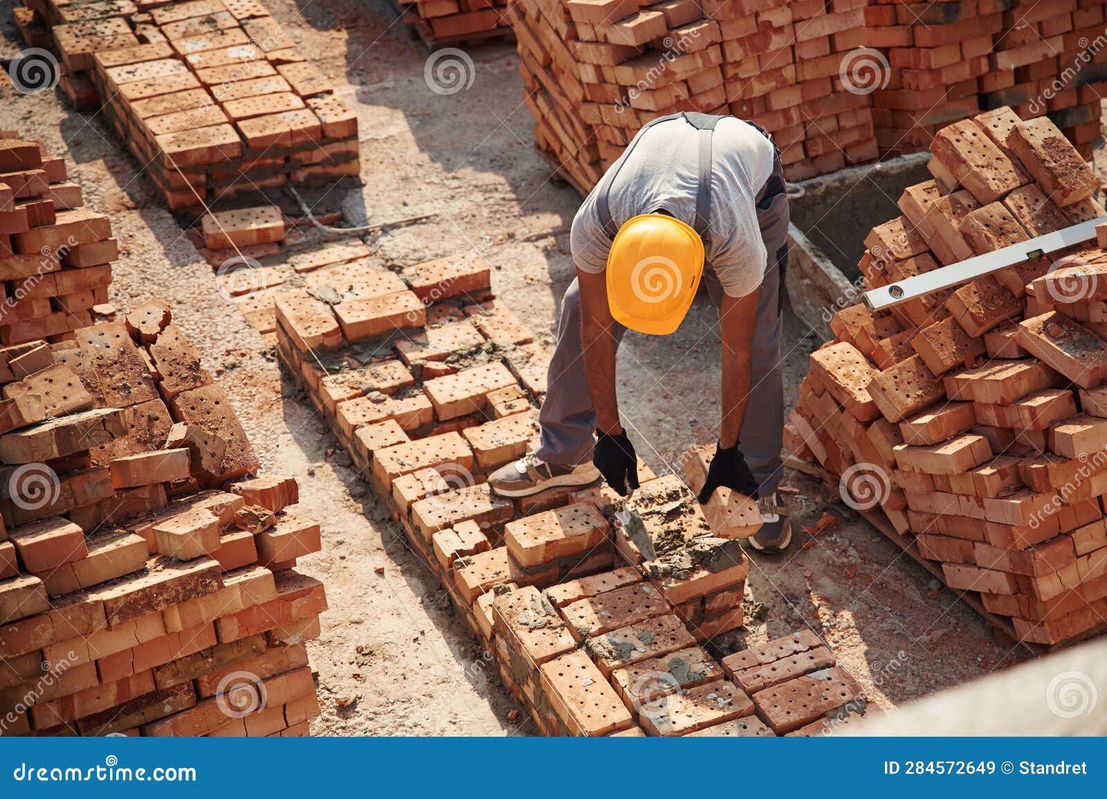 Showing and Holding Little Shovel and Brick. Handsome Indian Man is on ...