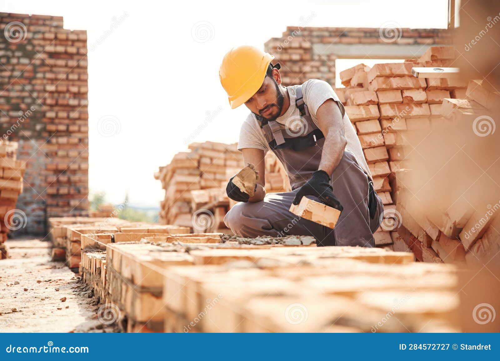 Showing and Holding Little Shovel and Brick. Handsome Indian Man is on ...