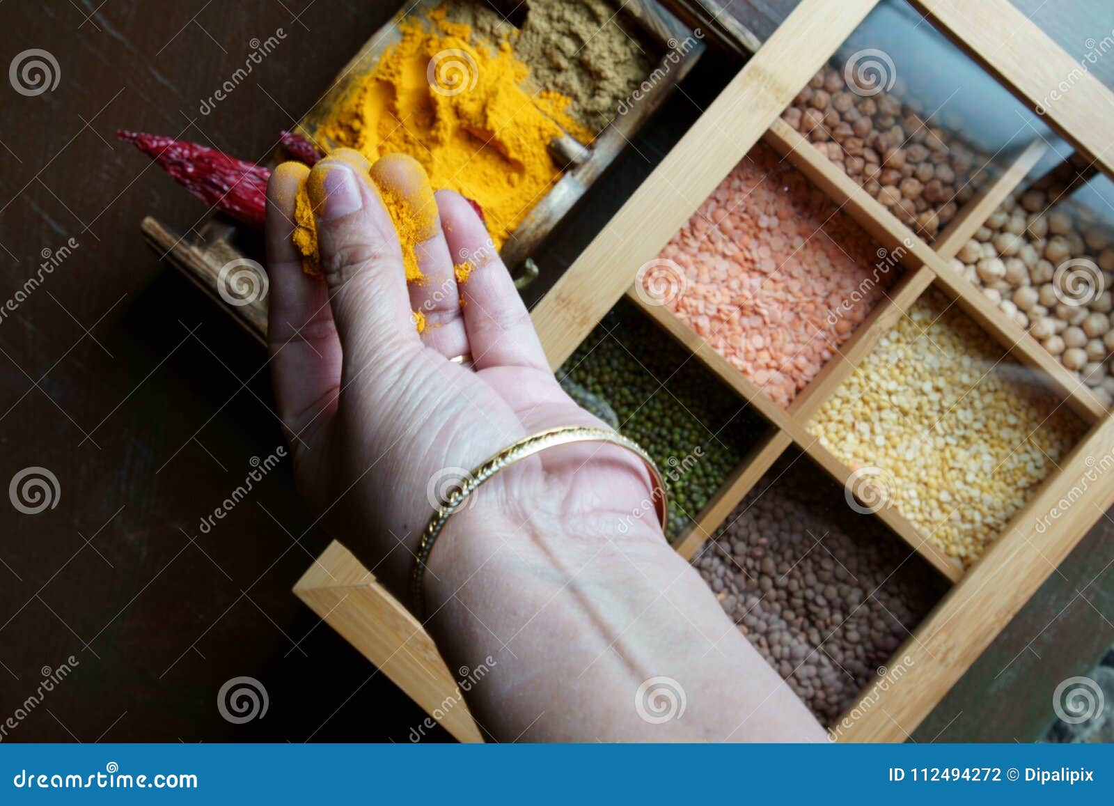 A Hand with a Pinch of Turmeric from a Spices Box. Stock Photo - Image ...