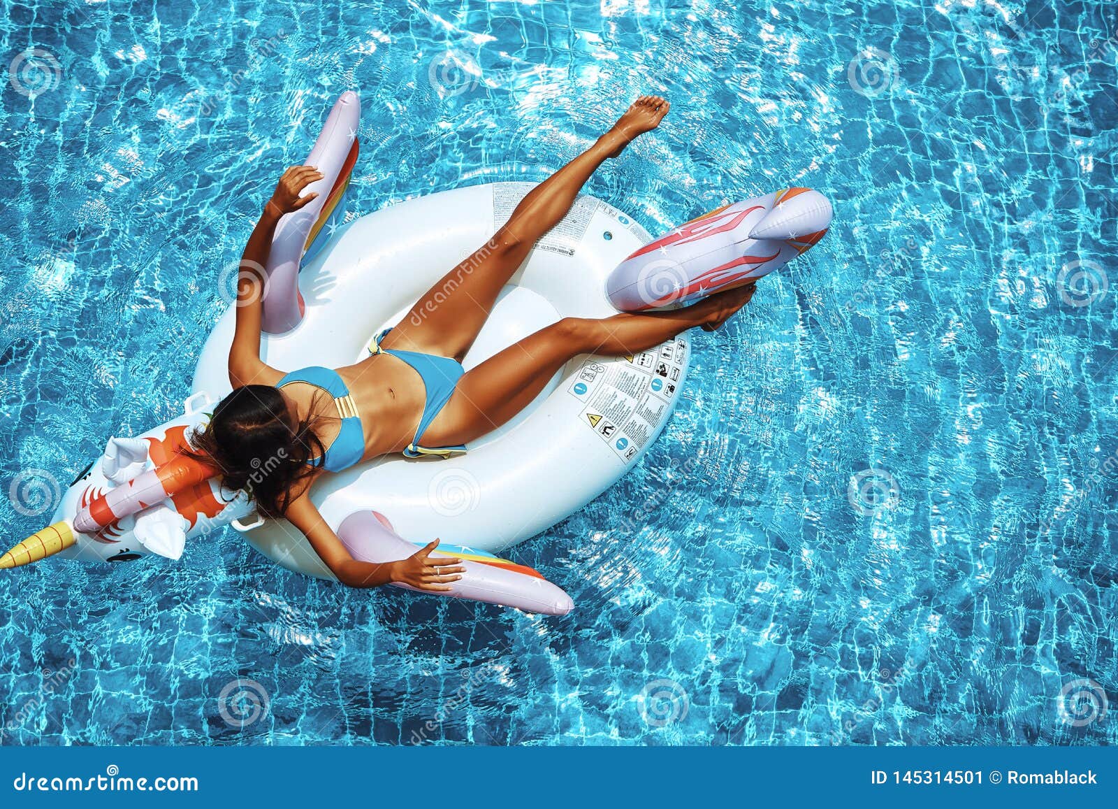 Asian Woman Wearing a Bikini and Relaxing on the Unicorn in a Swimming ... Asian Woman Wearing a Bikini and Relaxing on the Unicorn in a Swimming ...