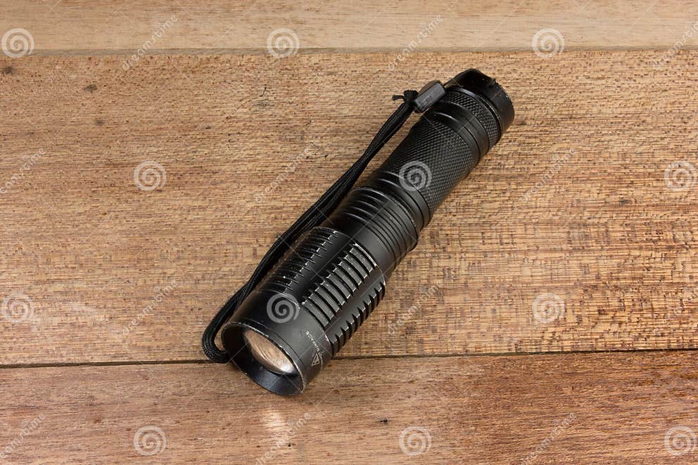 Top View of Black Technical Torch Light on a Wooden Surface with a Copy ...