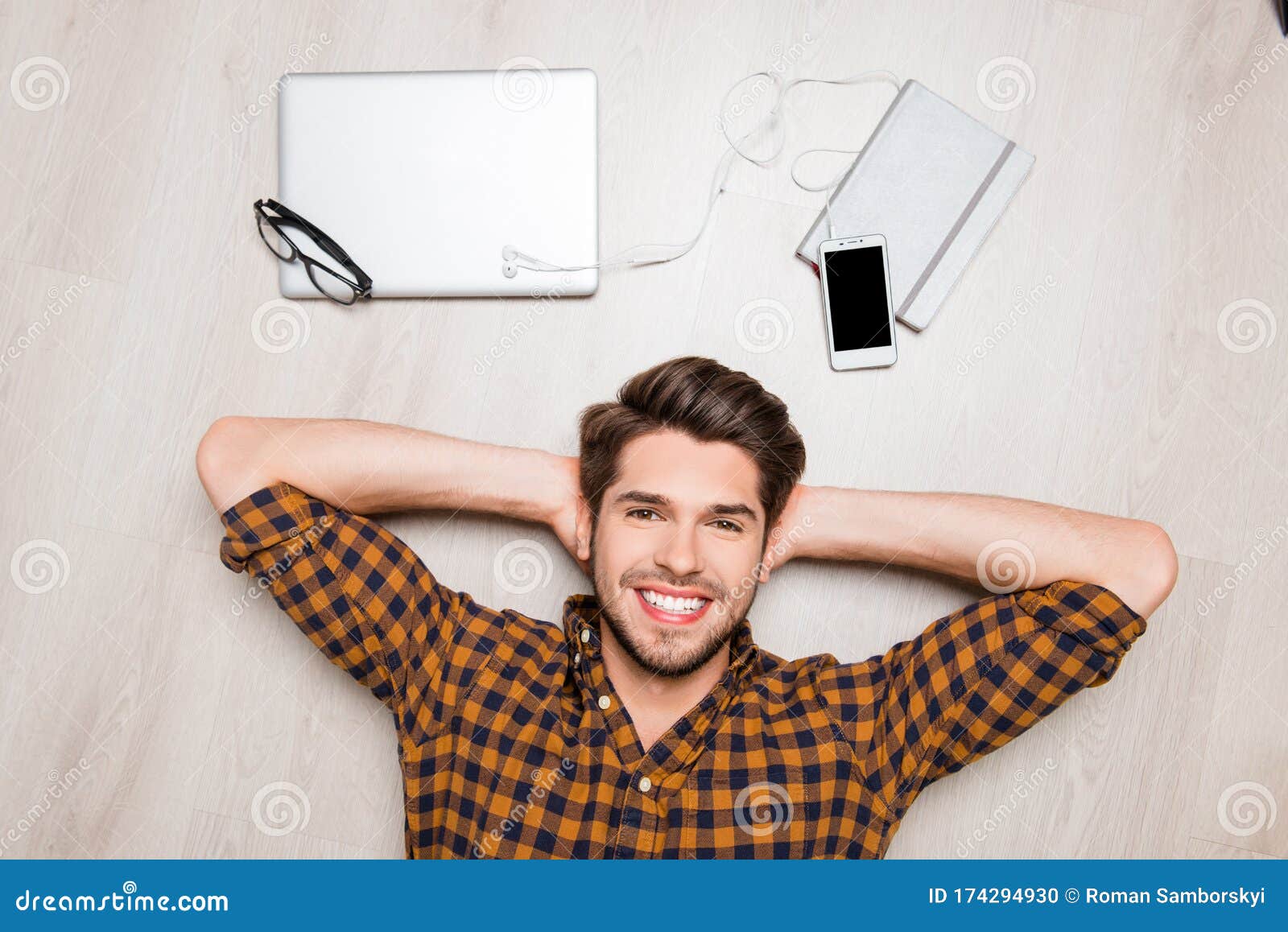 Top View of Cheerful Handsome Man Lying on Floor with Different Devices ...