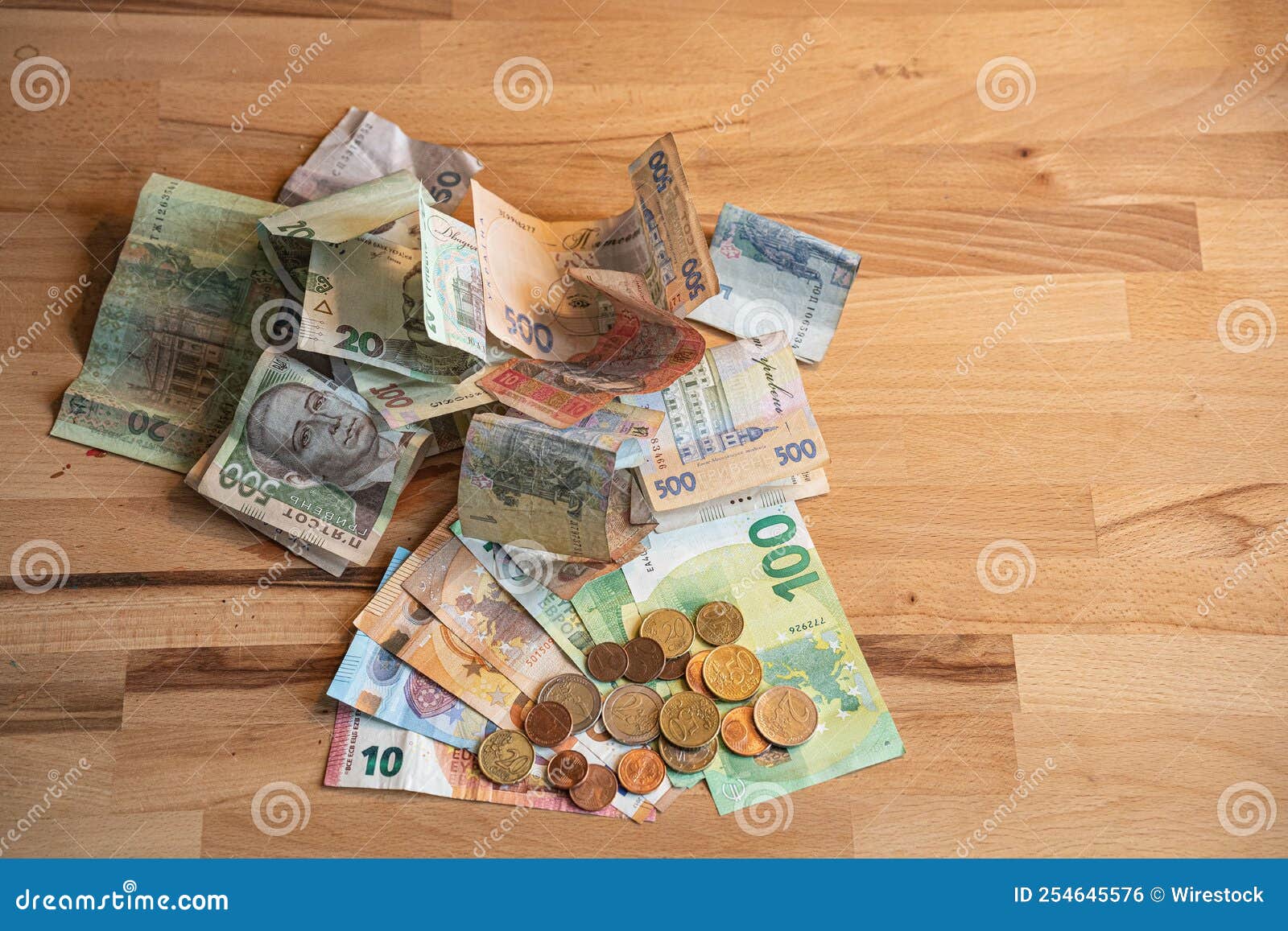 Top View of Different Types of Banknotes and Coins on a Wooden Surface ...