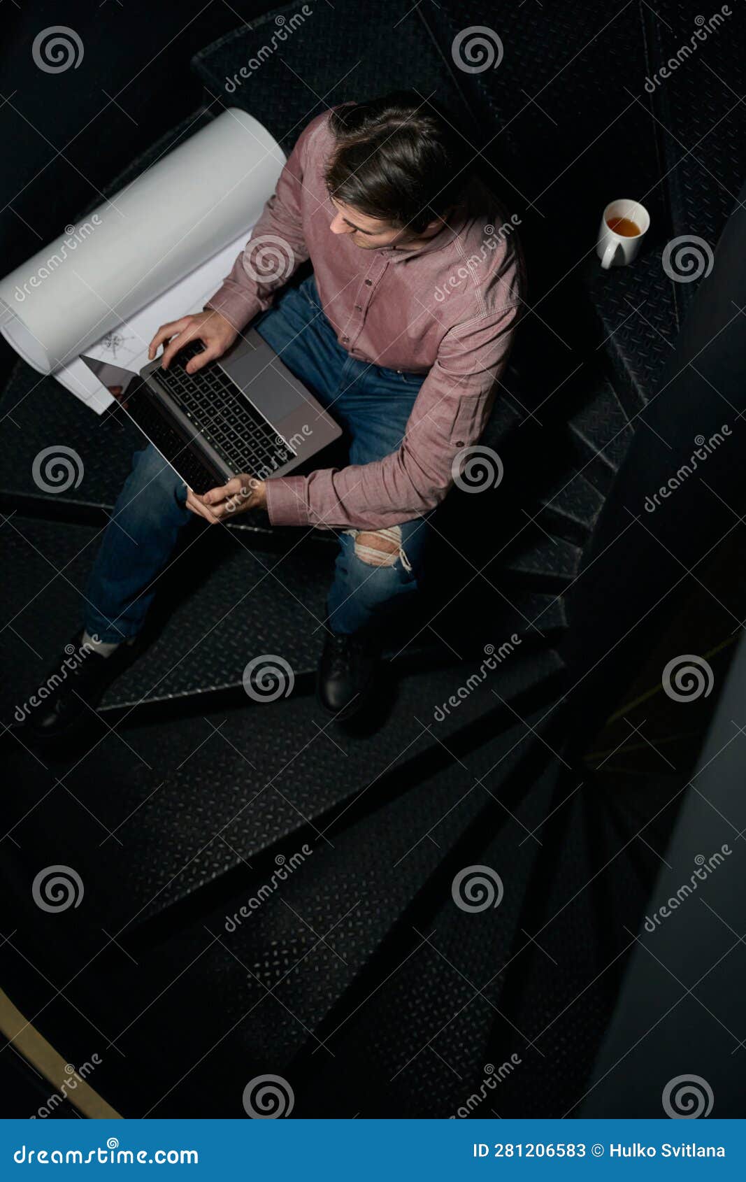 Drafter Using His Portable Computer on Spiral Staircase in Building ...