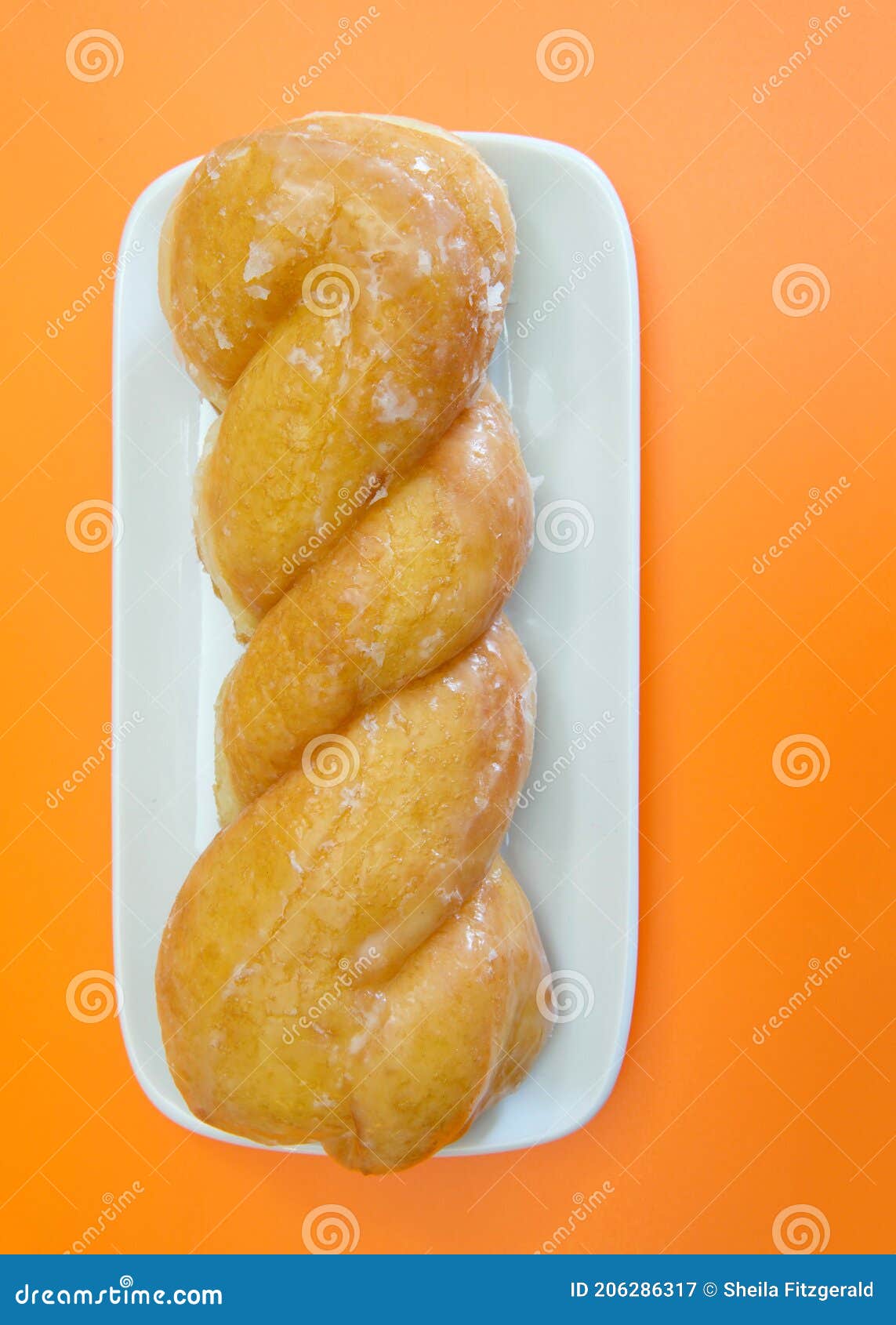 Glazed Twist Donut on Rectangle Plate Orange Background Stock Image ...