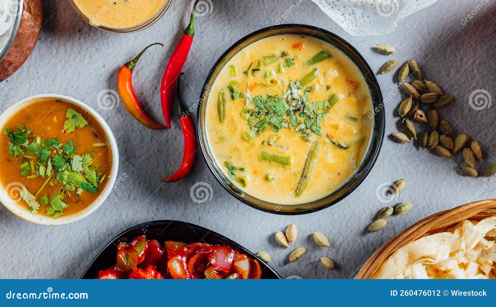 Top View of Green Curry with Rasam Soup and Red Jalapenos on a White ...