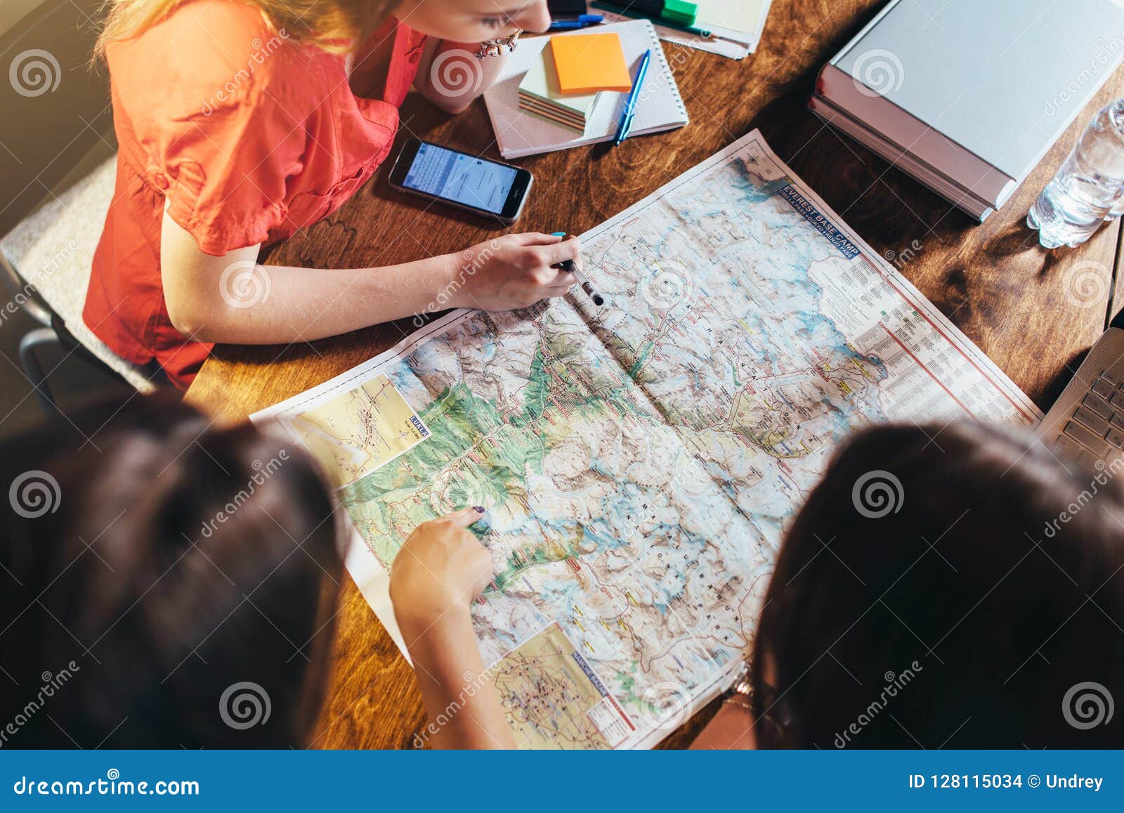 Top View of Group of Female Students Studying the Map Sitting at Desk ...