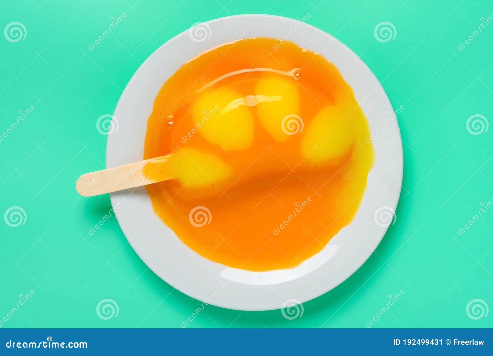 Half Melted Orange Shape and Flavor Popsicle on a Plate Stock Image ...