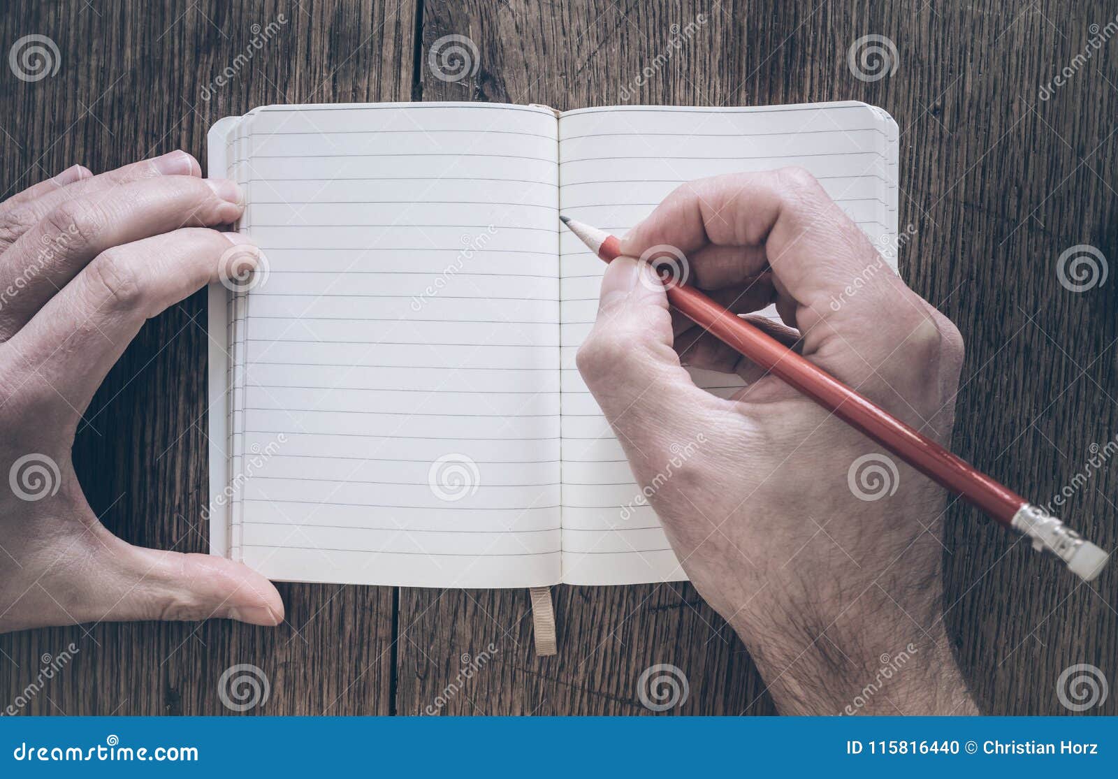 Top View of Man Holding Pencil To Write on Notepad on Wooden Desk Stock ...