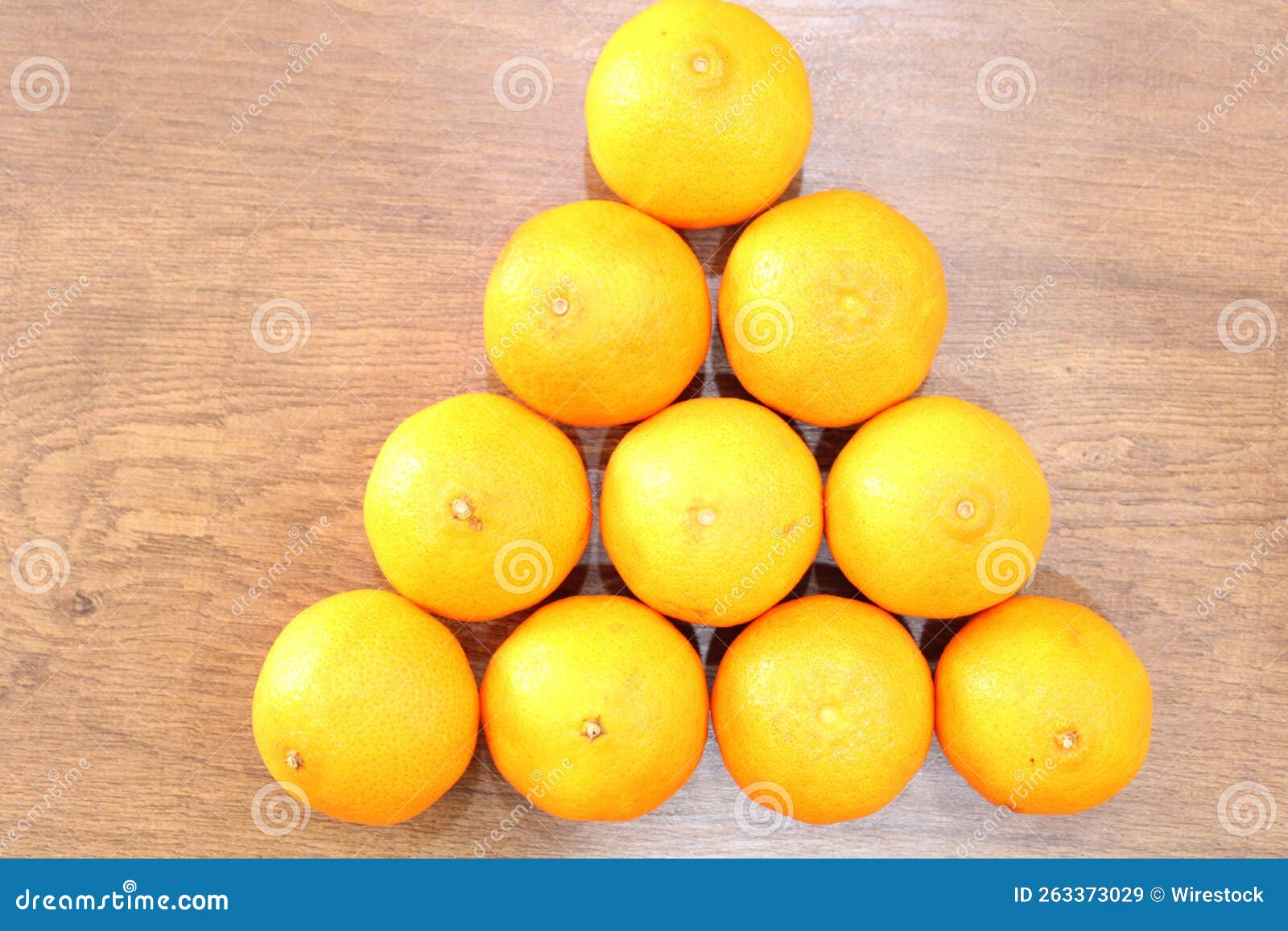 Top View of Orange Fruits Arranged in a Triangular Shape on a Wooden ...