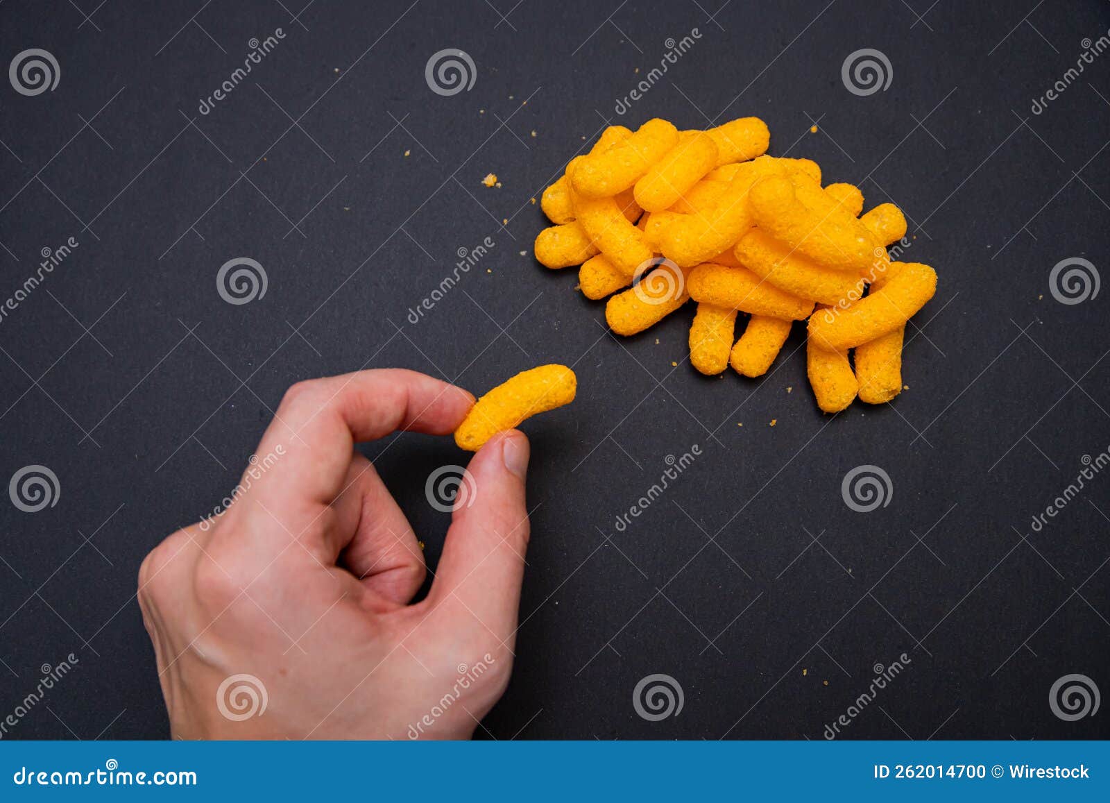 Top View of a Person Taking a Cheese Puff on a Black Surface Stock ...