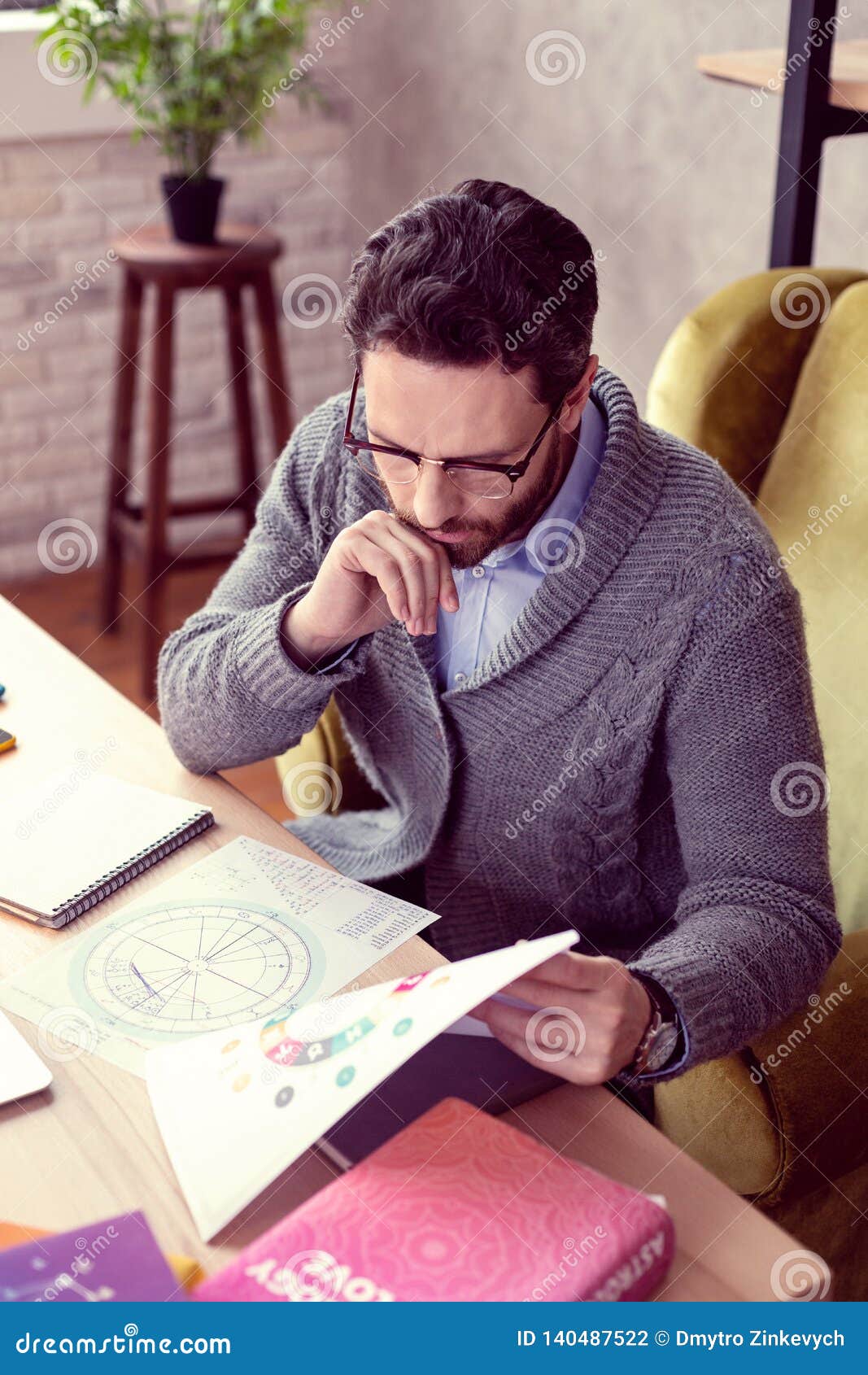 Bearded Astrologist Sitting In Armchair Reading Book And Doing Practice ...