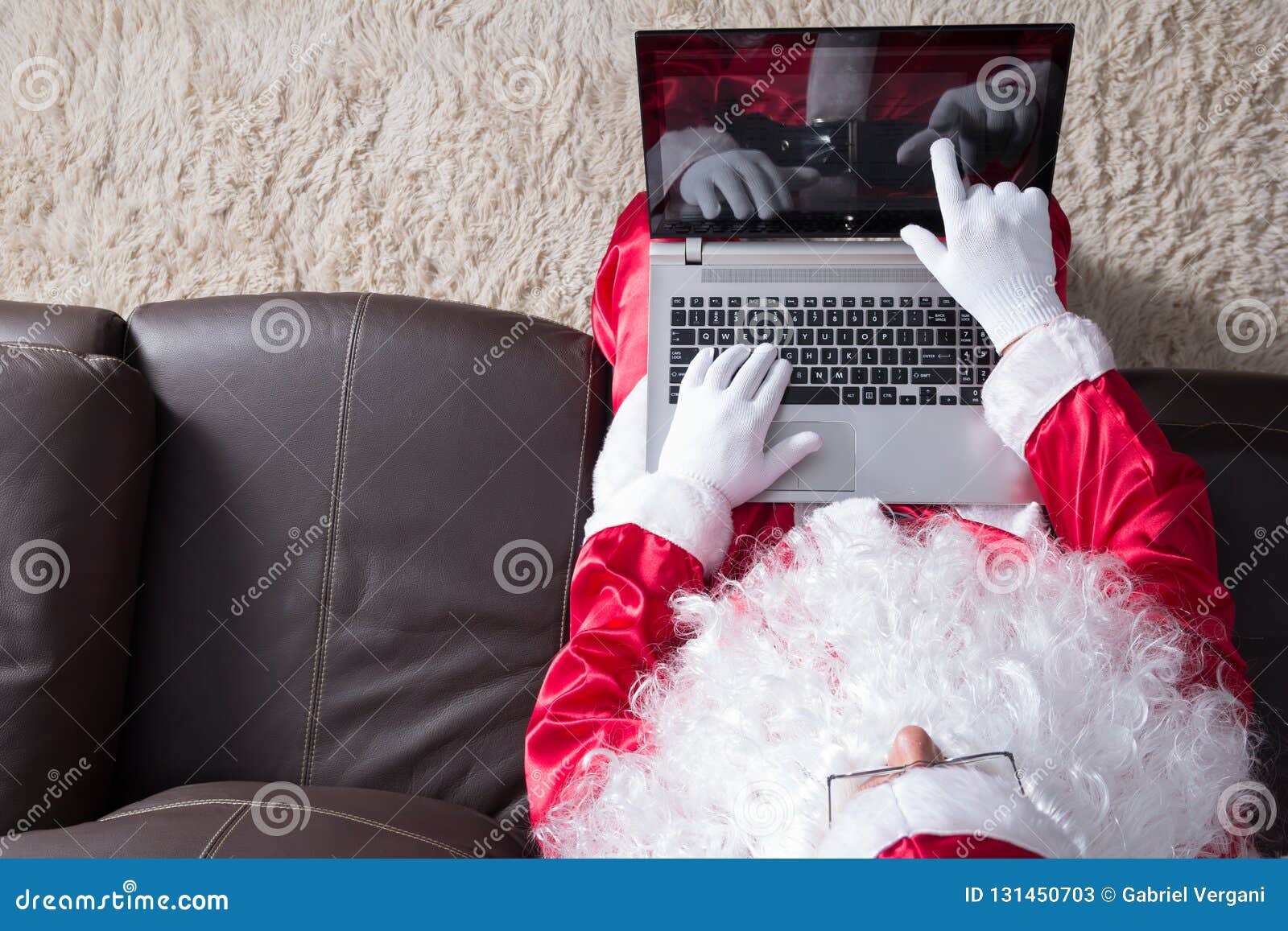Top View of Santa Claus Sitting in Couch Using Laptop and Pointing at ...