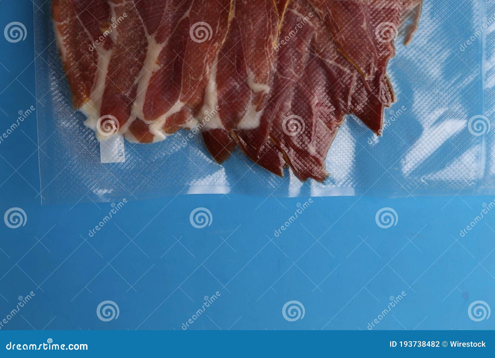 Top View of Serrano Ham Slices in a Plastic Vacuum Bag on a Blue ...