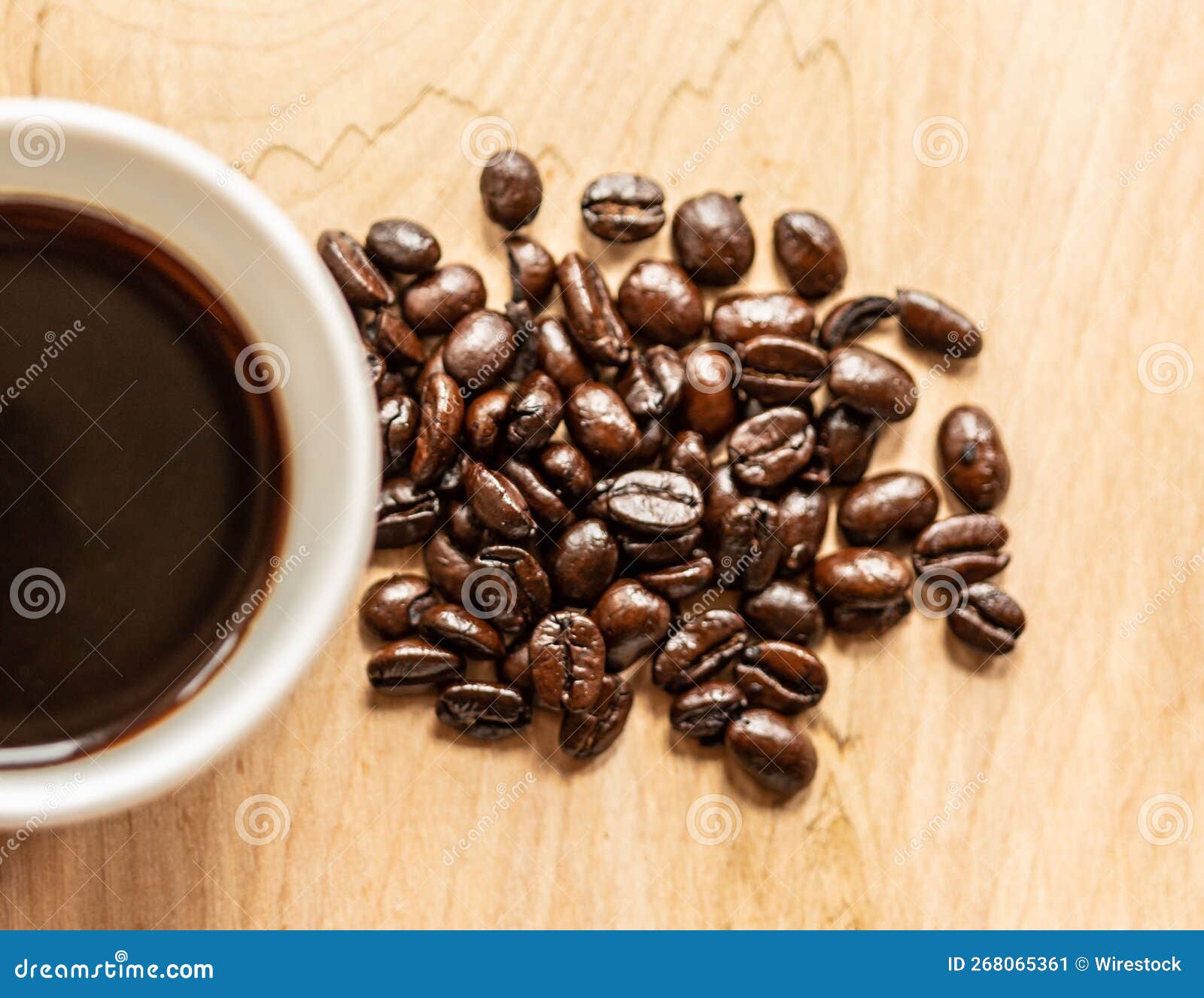 Top View Shot of a Bunch of Coffee Beans and a Half Full Coffee Cup ...