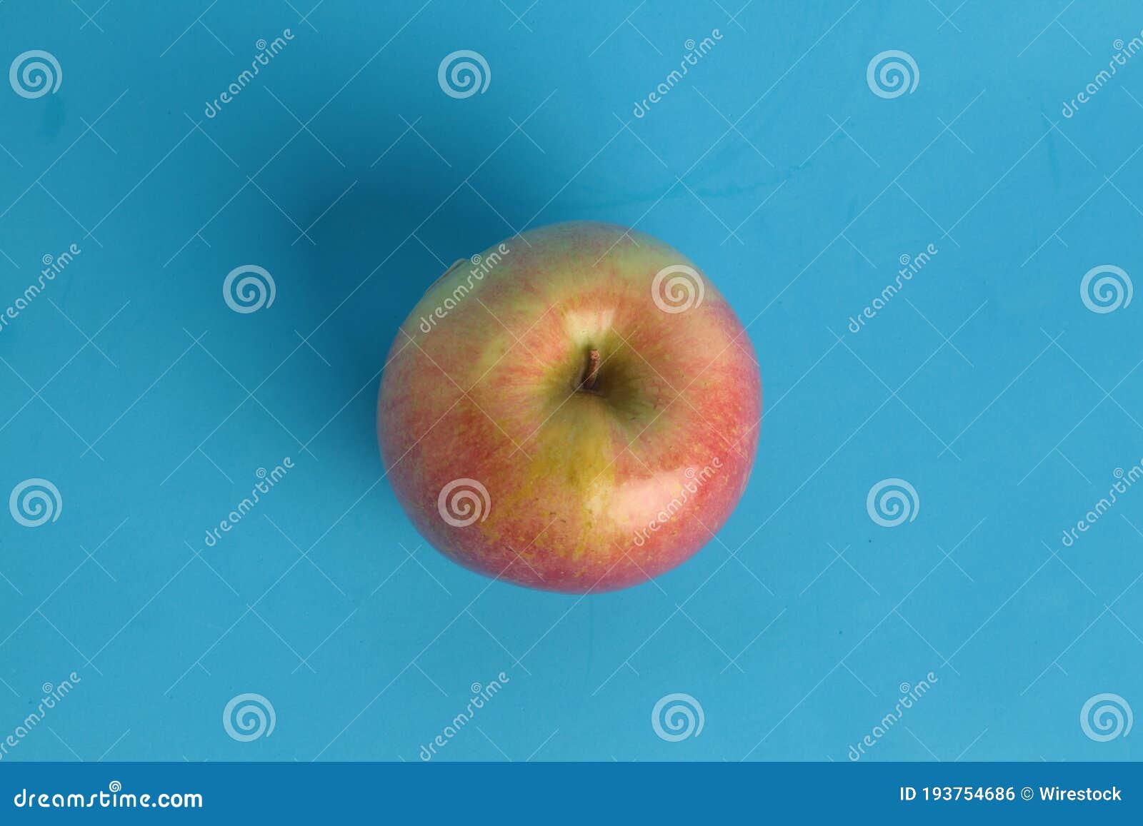 Top View of a Whole Apple Under the Lights Isolated on a Blue ...