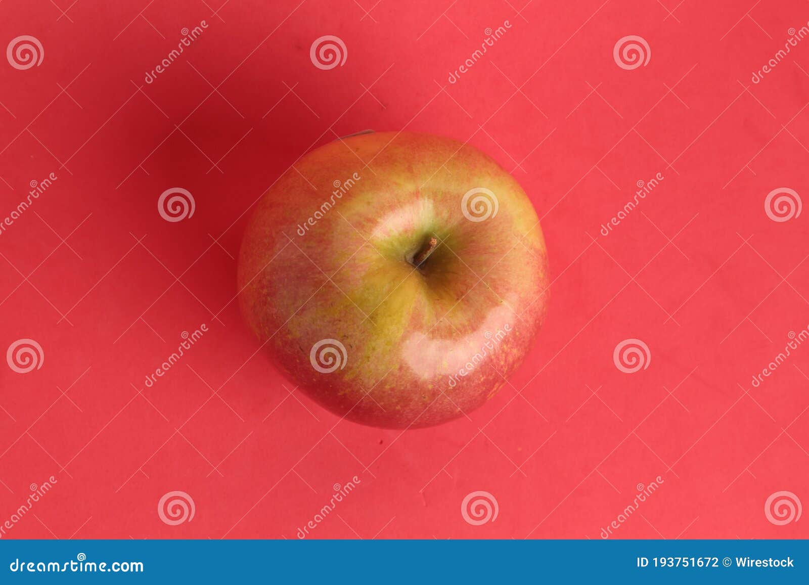 Top View of a Whole Apple Under the Lights on a Red Surface Stock Photo ...
