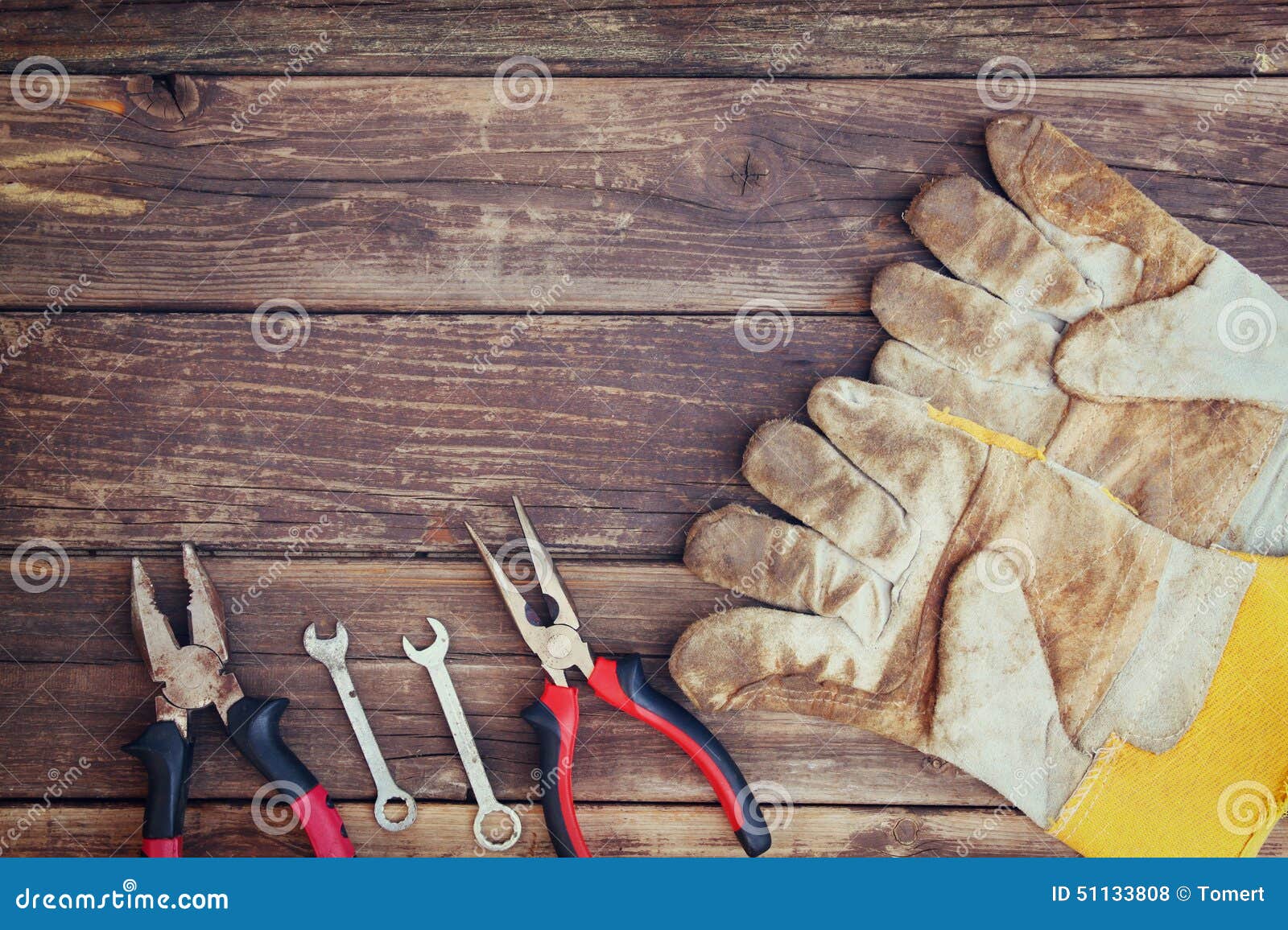 Top View of Worn Work Gloves and Assorted Work Tools Over Wooden ...