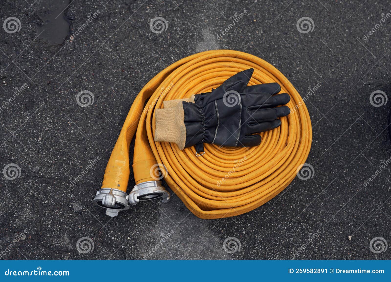 Top View of Yellow Fire Hose with Black Gloves on it on the Ground ...