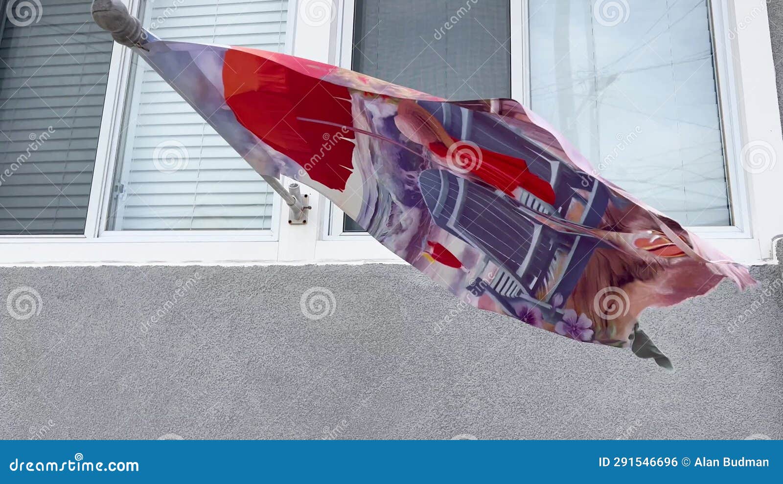 Torn Decorative Flag Flag in Front of a Gray House Seen Flapping in a ...