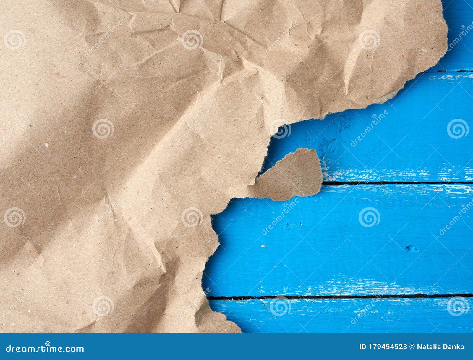 Torn Piece of Paper on Blue Wooden Background Stock Photo - Image of ...