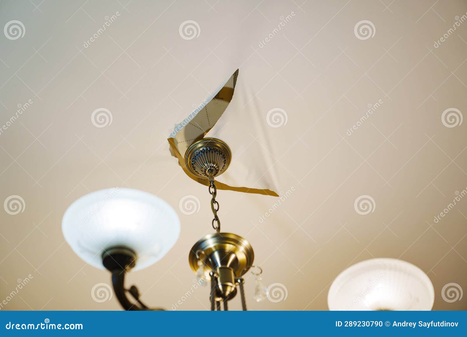A Torn Stretch Ceiling with a Ceiling Lamp Stock Photo - Image of ...