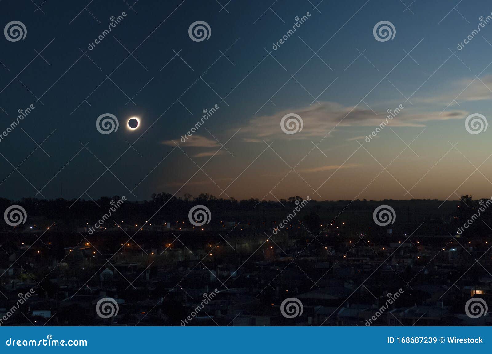 Total Solar Eclipse during the Evening Above a Modern Town Surrounded ...