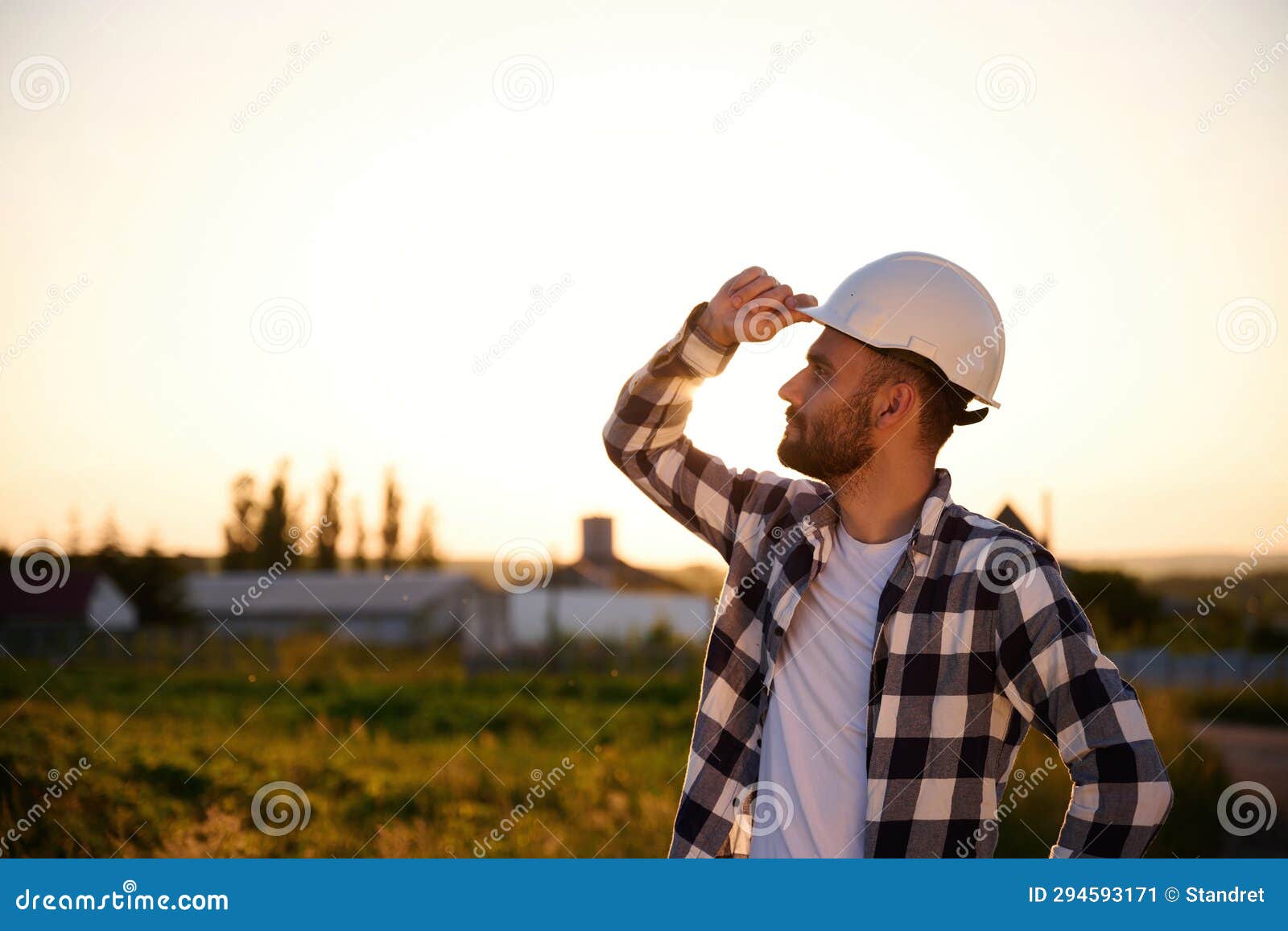 Man in Hard Hat is Outdoors Against Sunset Light. Rural Scene Stock ...