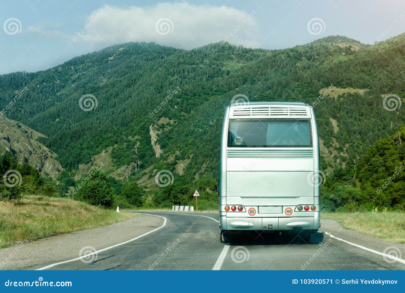 Tourist Bus on the Road among the Green Mountains. Back View Stock ...
