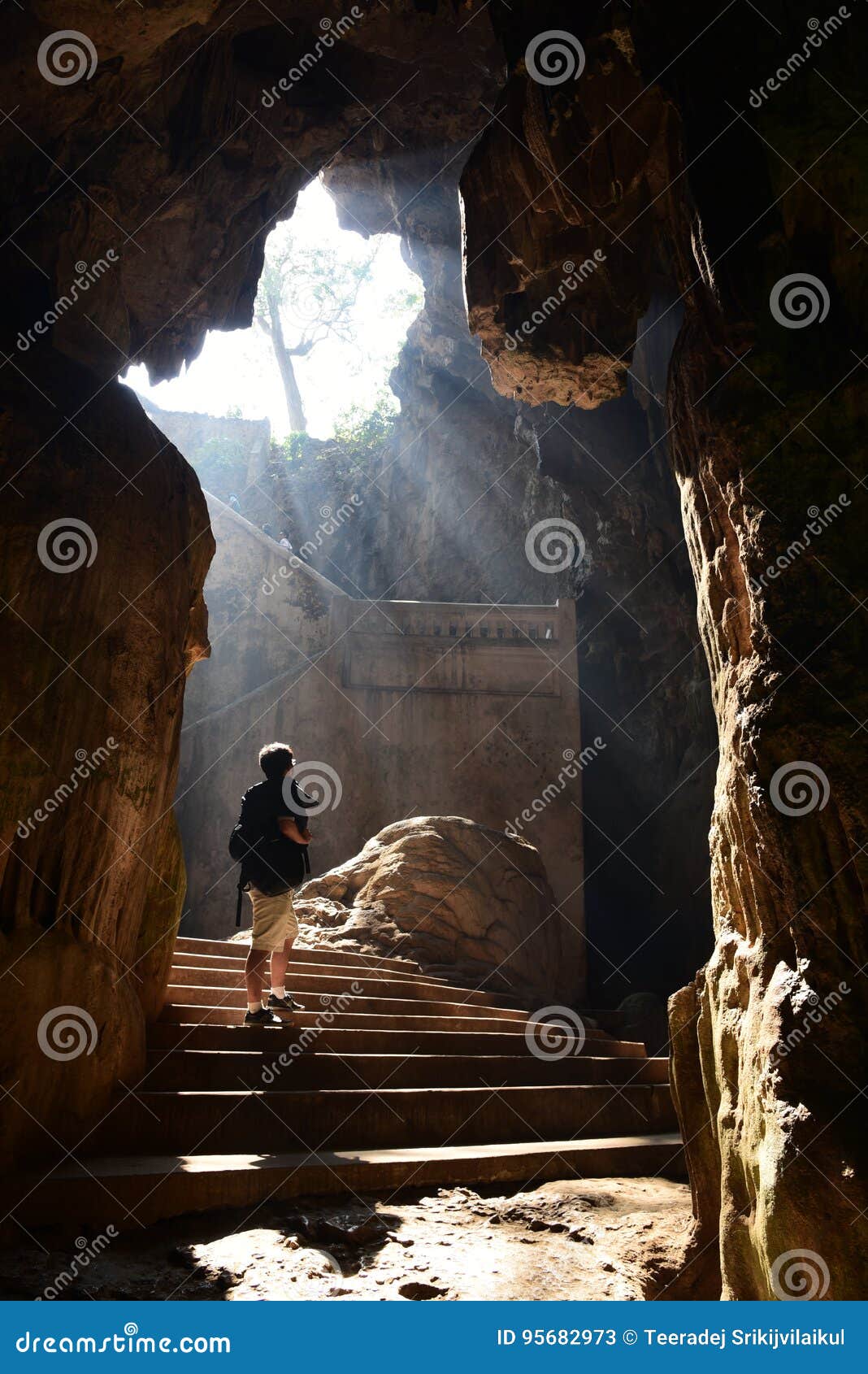 A Tourist in the Cave with Light Beams Stock Image - Image of statue ...