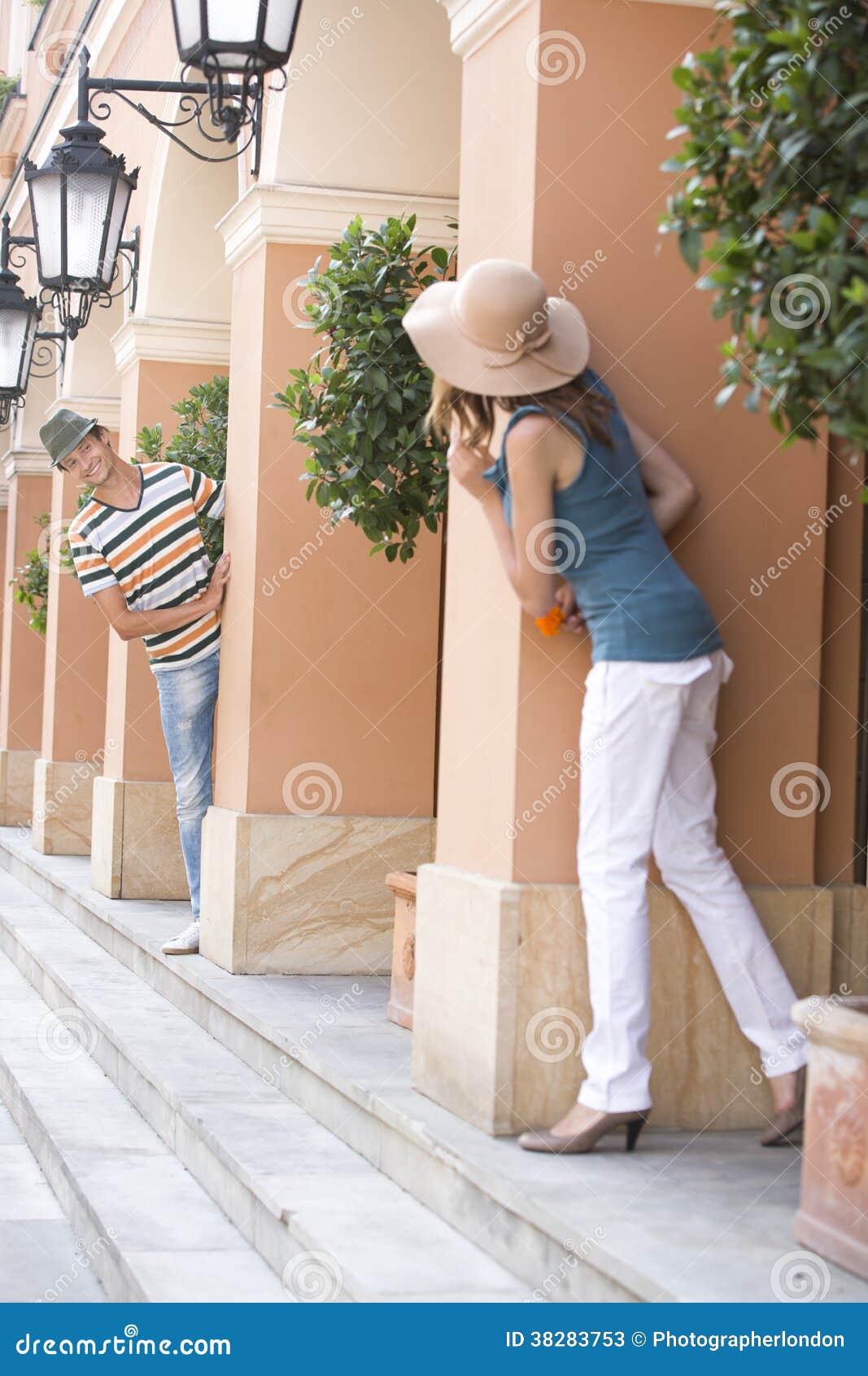 Tourist Couple Looking at Each Other while Hiding Behind Columns Stock ...