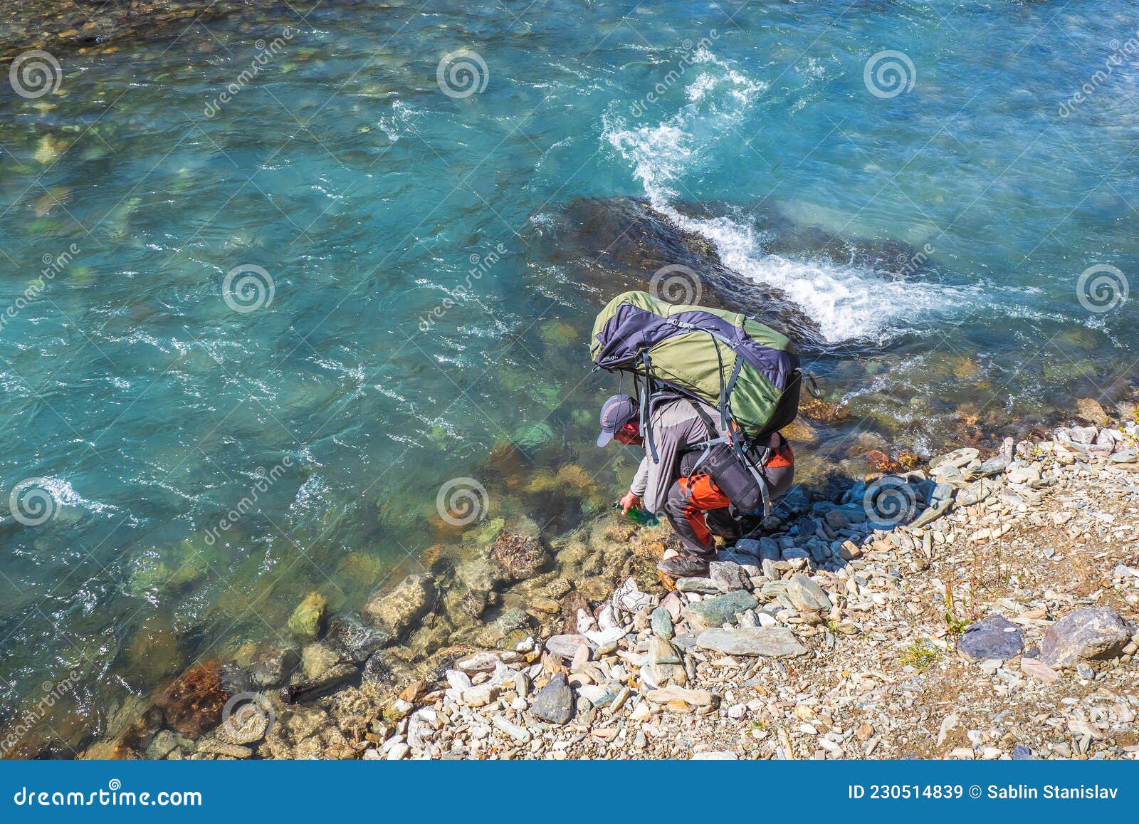 Touristic Man with Big Backpack Drinking Water from the River. Clean ...