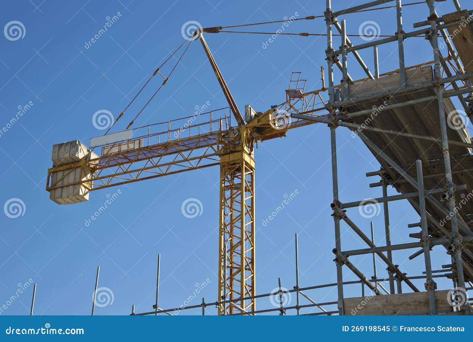 Tower Crane in a Construction Site with Metal Scaffolding To Work on ...