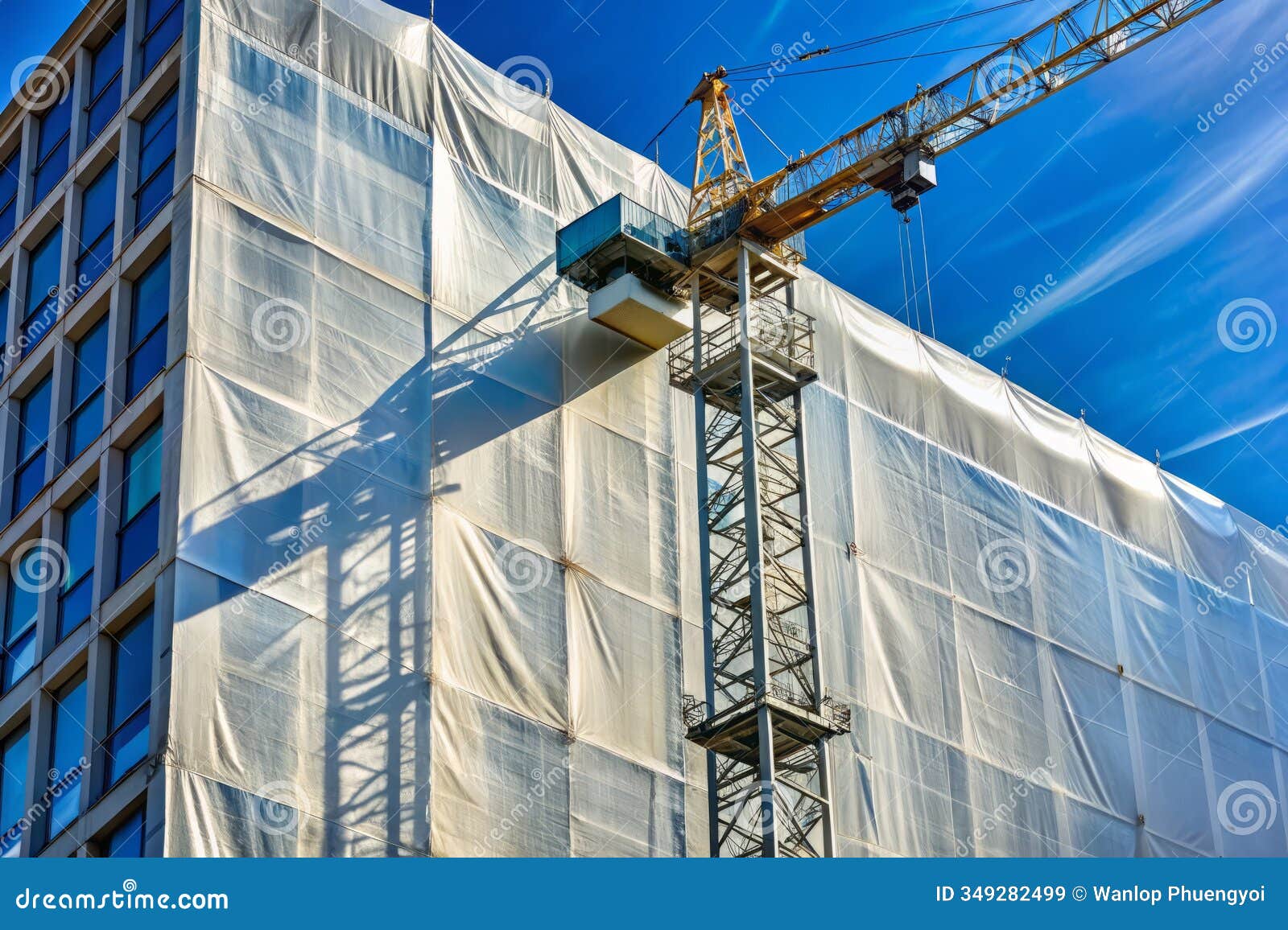Construction Crane Shadow Casts Long Reflection on a Building Encased ...