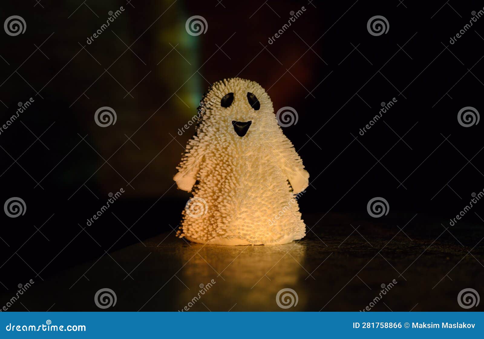 A Toy Smiling Ghost Stands in the Dark and is Illuminated by a Reddish ...