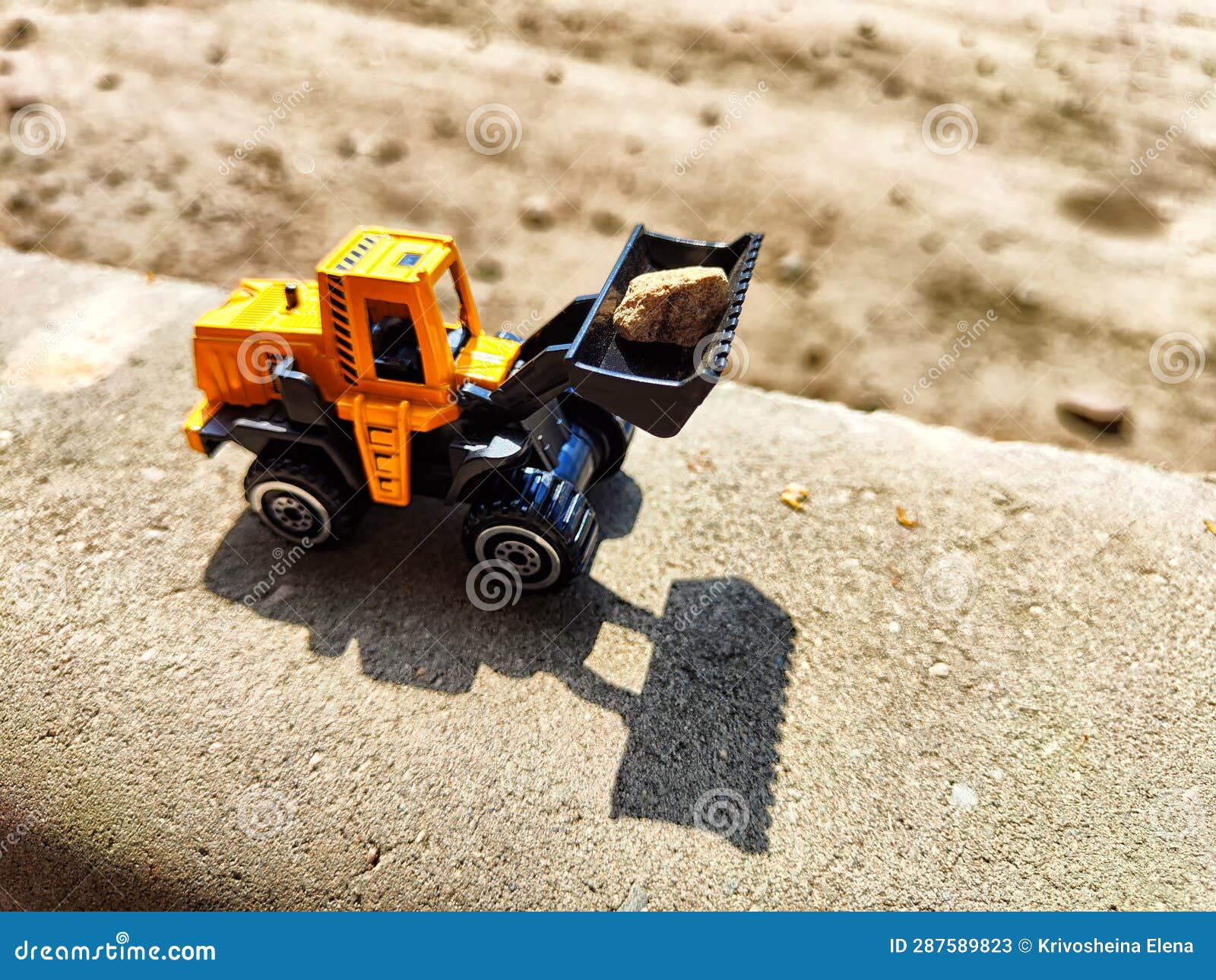 Toy Yellow Tractor or Excavator with a Bucket during Operation. Road or ...