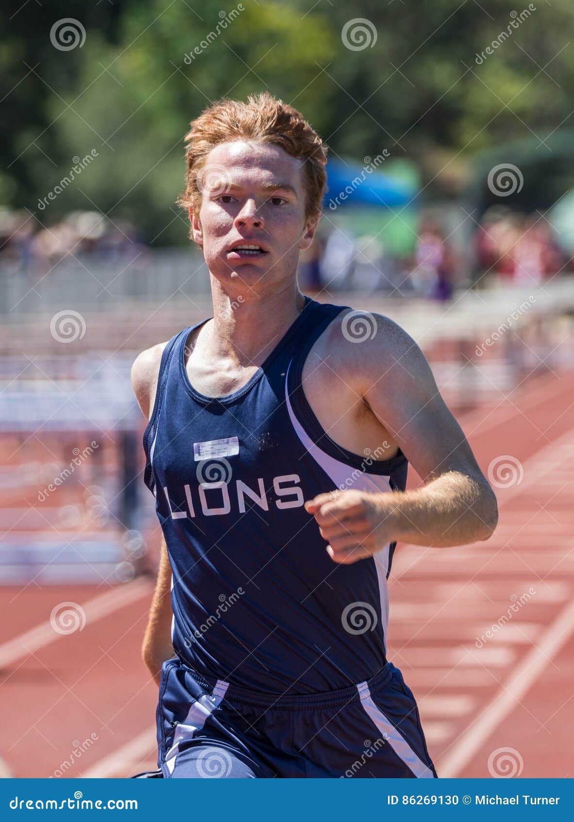 Track Runner Running Over A Hurdle On A Parking Lot Wearing A Face Mask ...