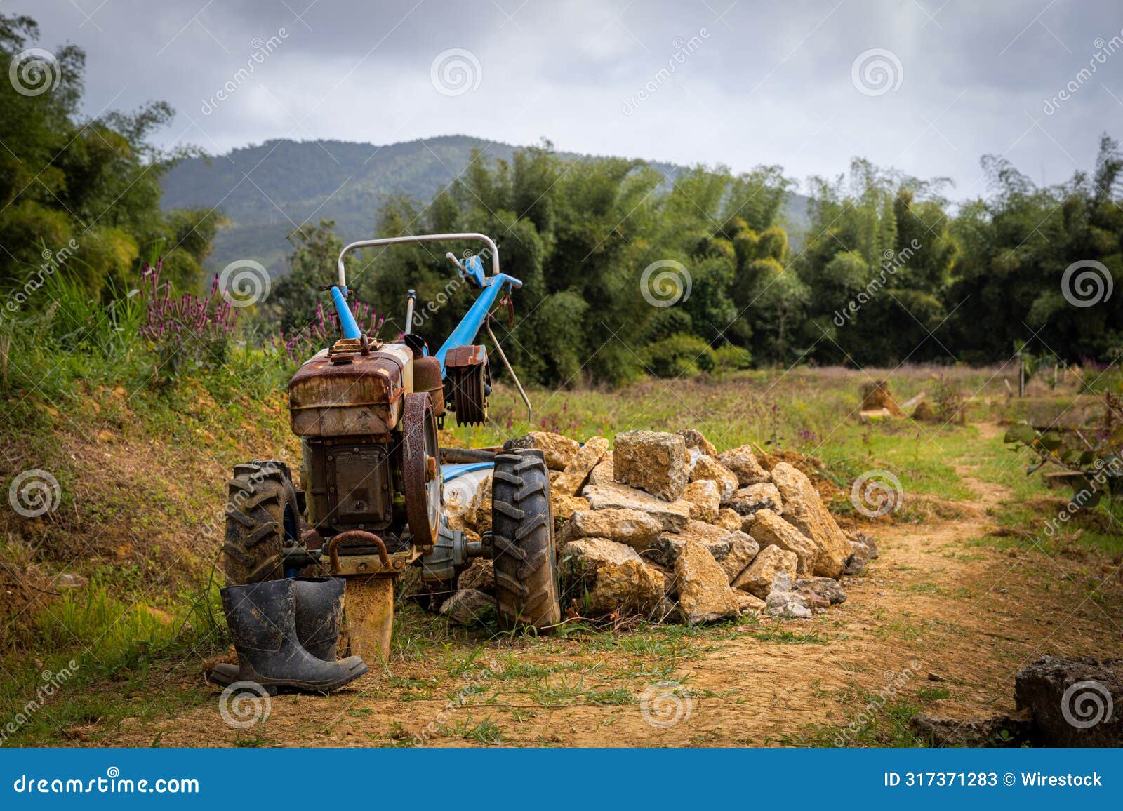 A Tractor with Buckets on the Front is in Front of a Rock Wall Stock ...