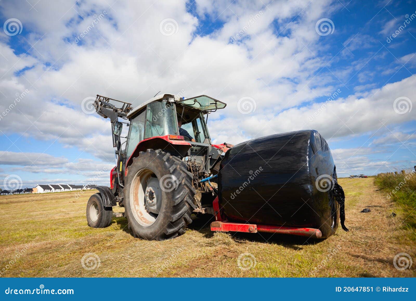 Tractor Collecting a Roll of Haystack in the Field Stock Image - Image ...