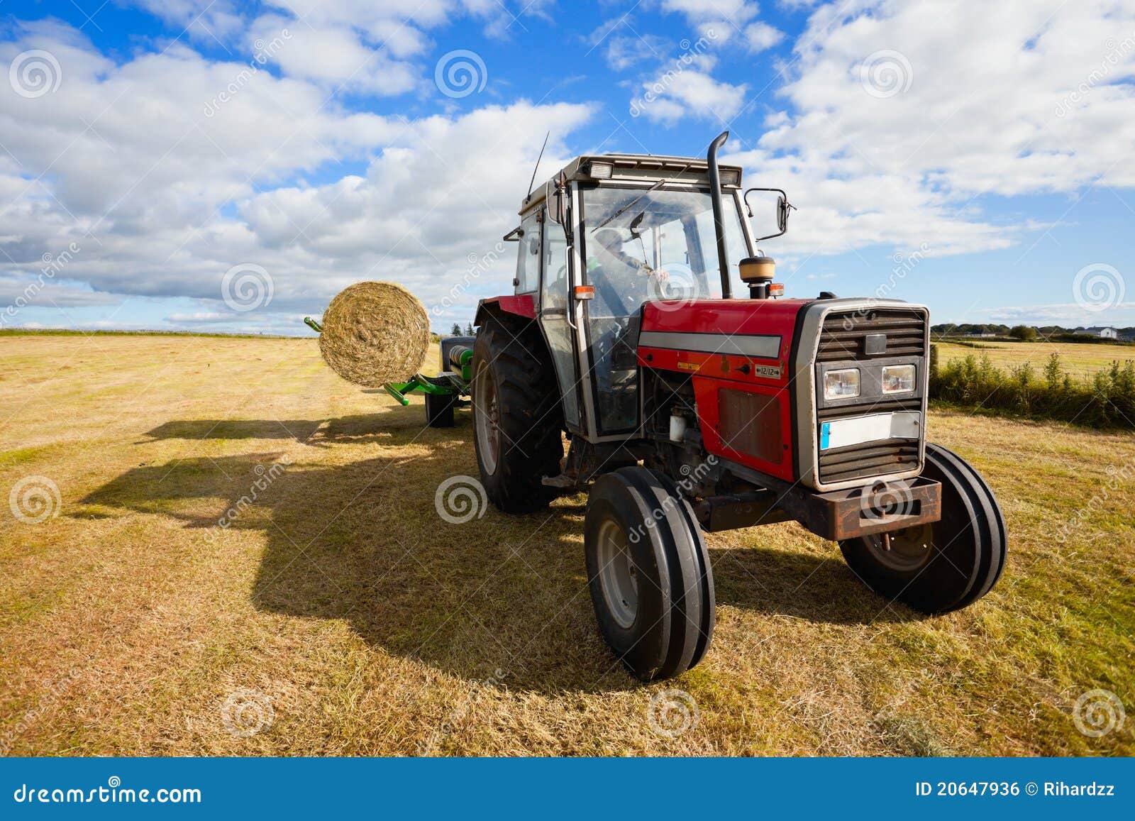 Tractor Collecting a Roll of Haystack in the Field Stock Photo - Image ...