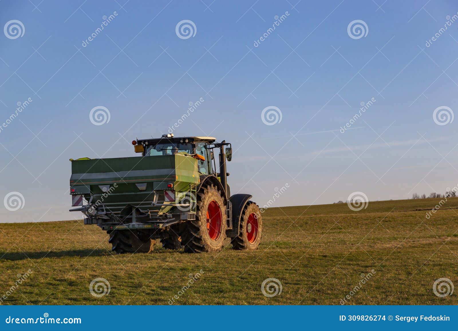 Tractor driving on a field stock photo. Image of farmer - 309826274