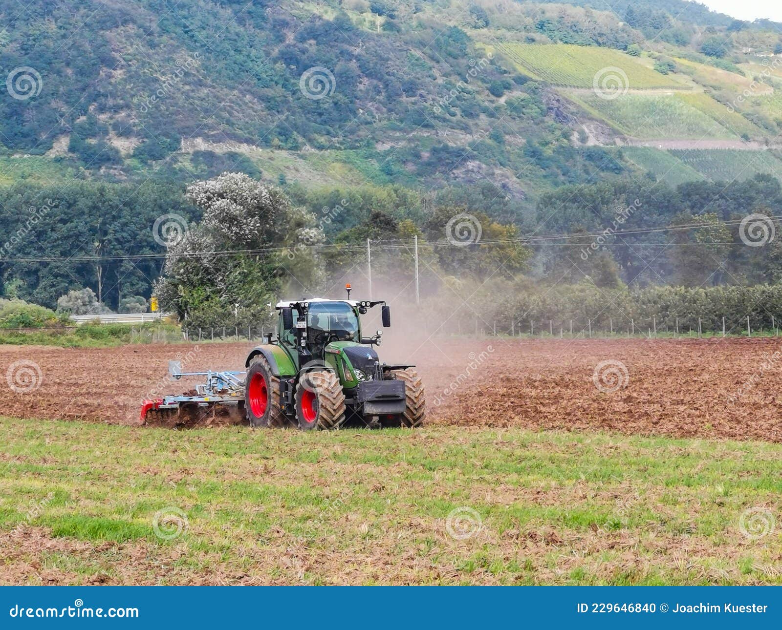 A Tractor on a Wide Field Harrowing the Plowed Acre Stock Photo - Image ...