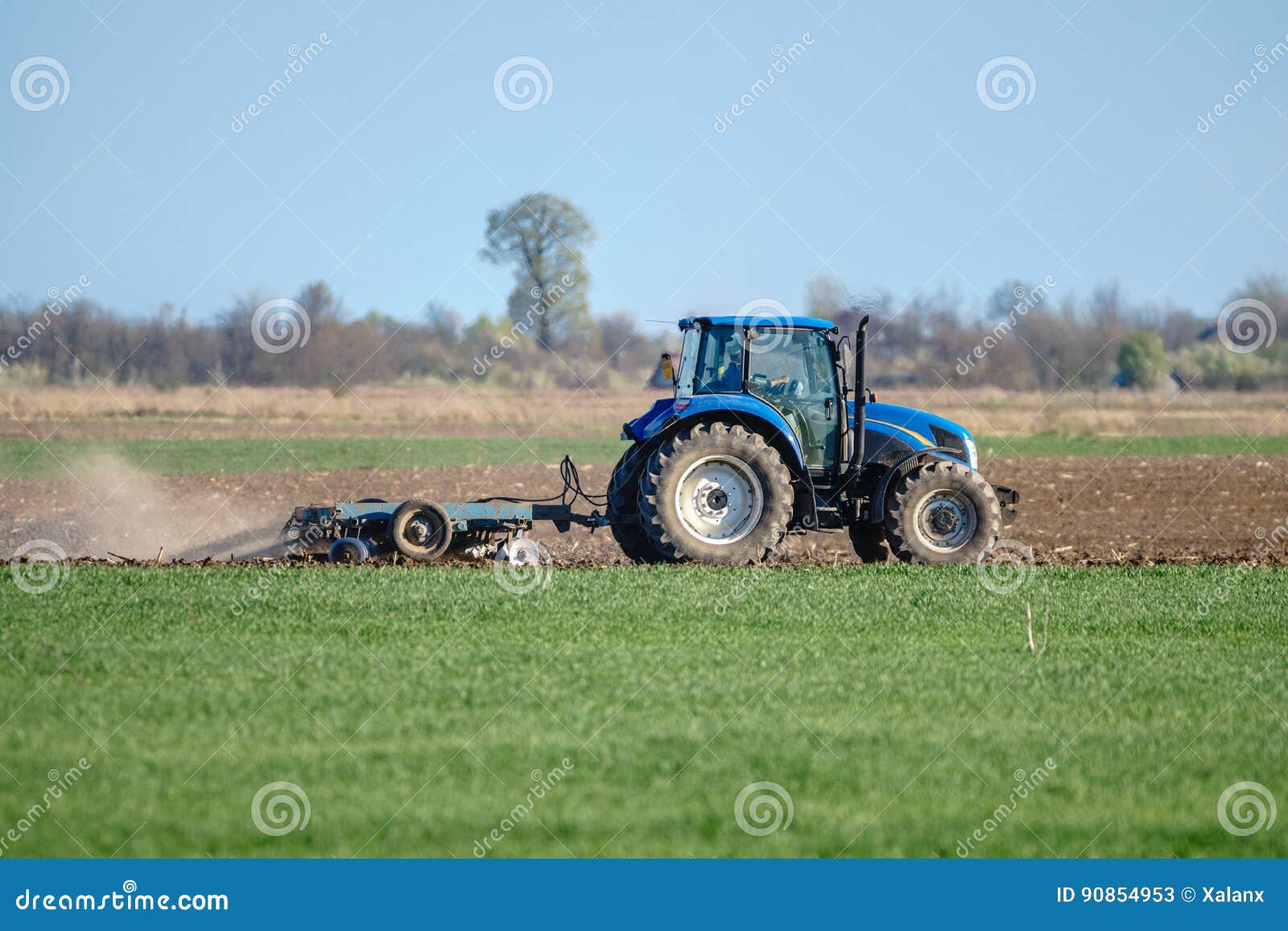 Tractor harrowing the land editorial stock photo. Image of land - 90854953