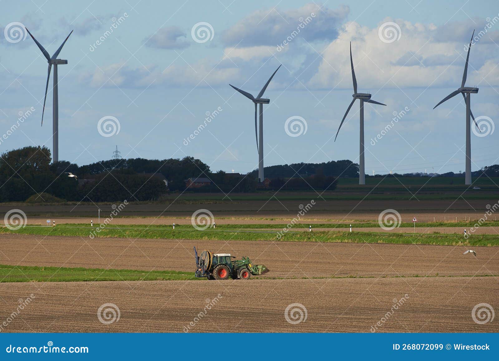 Tractor in a Large Field in Front of Windmills Editorial Stock Image ...